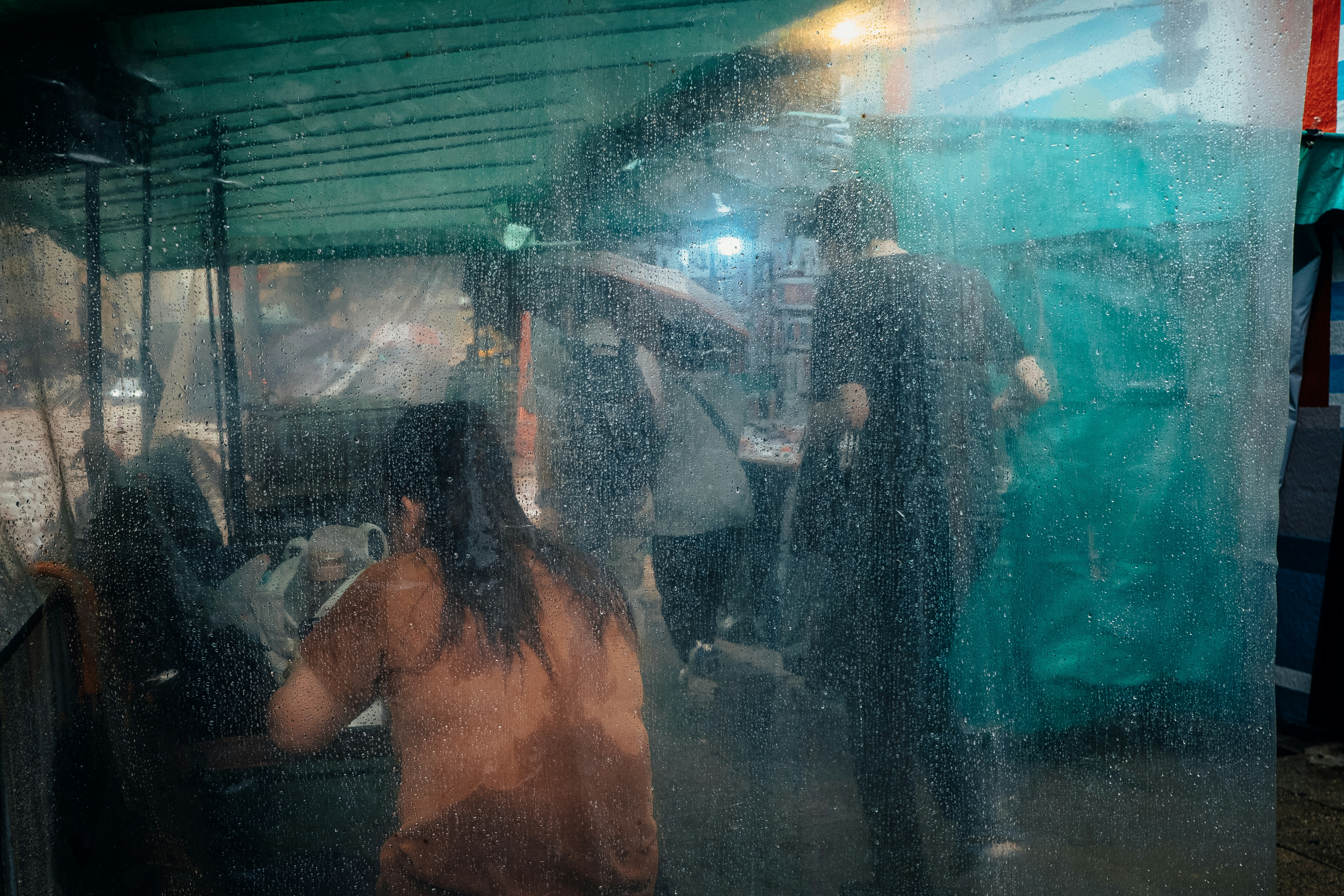 Crowded Shelter Under Turquoise Canopy
