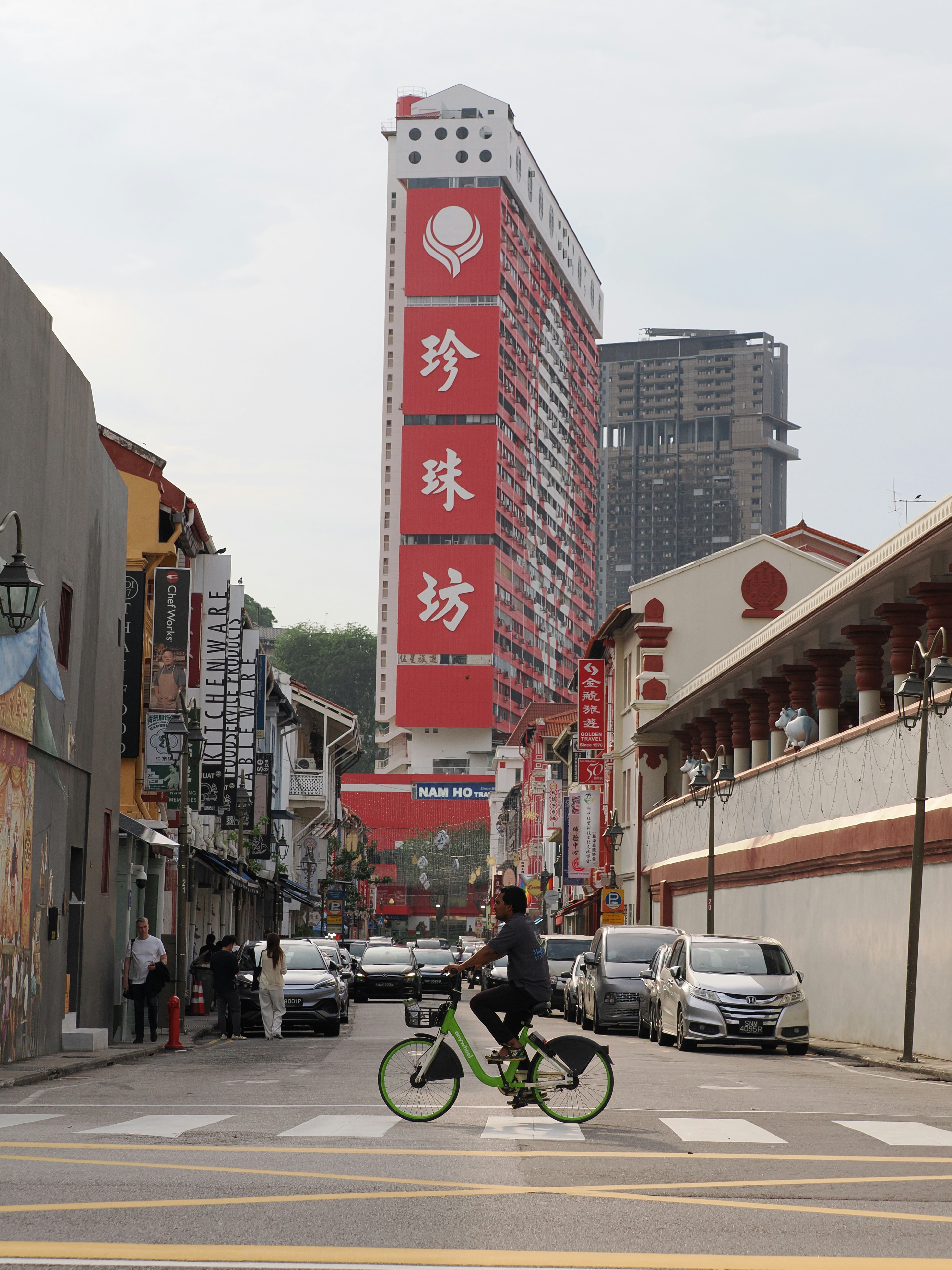 Neon Red Skyline: A Cyclist Traverses Chinatown’s Urban Rhythm