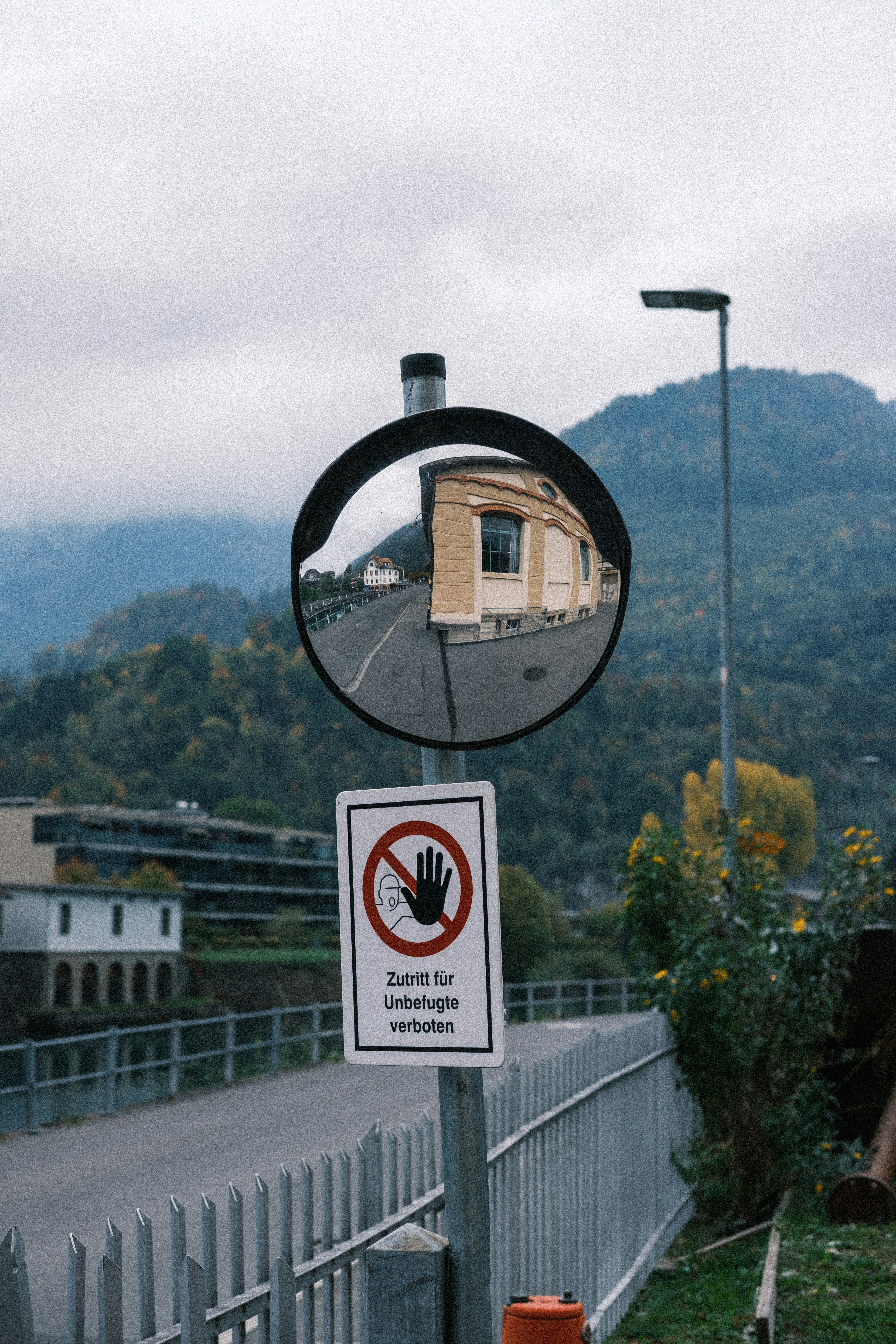 Convex Mirror Overlook: Street, Signage, and Hillside Echo