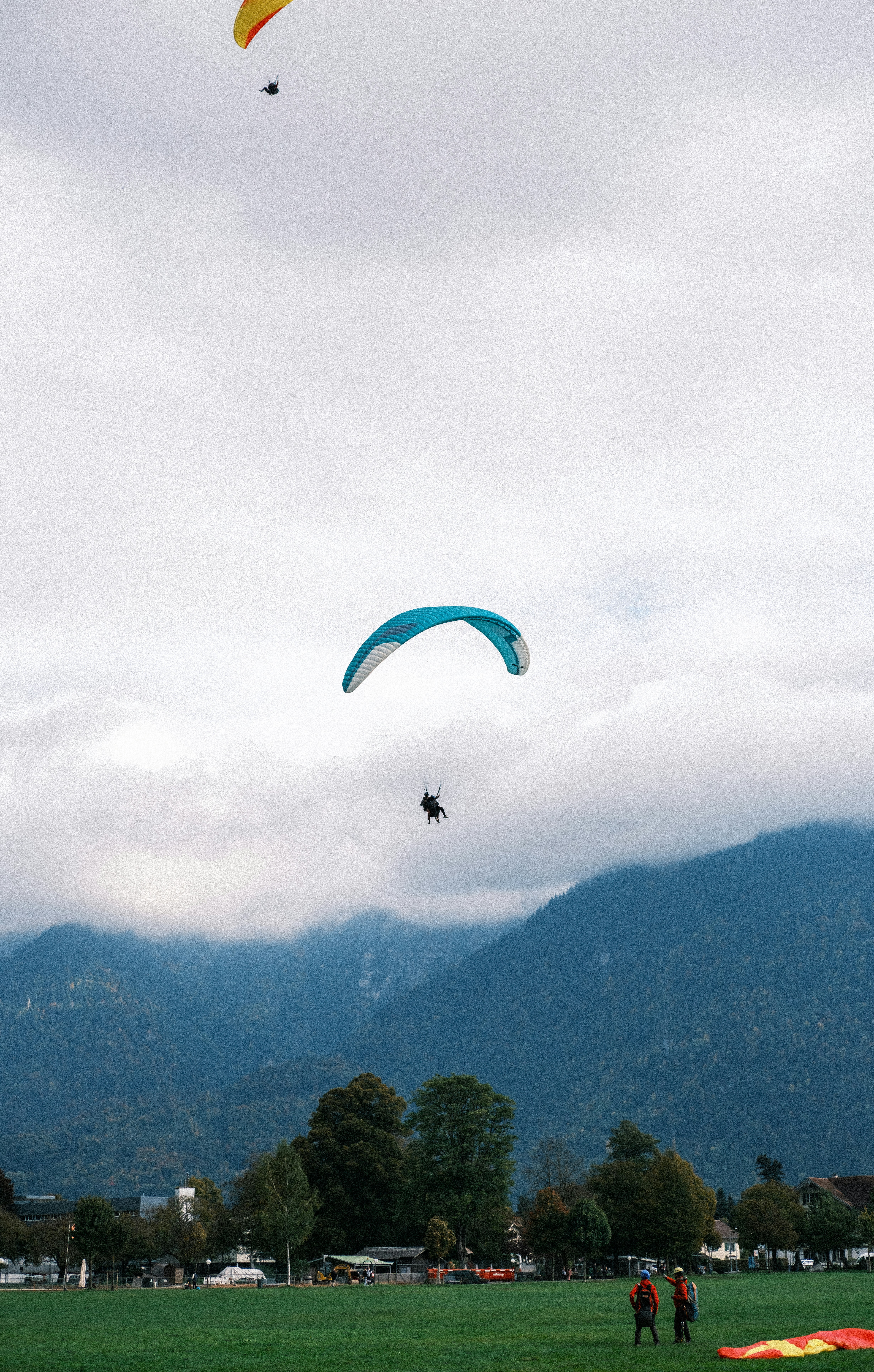 Paragliders Above a Quiet Lakeside Field