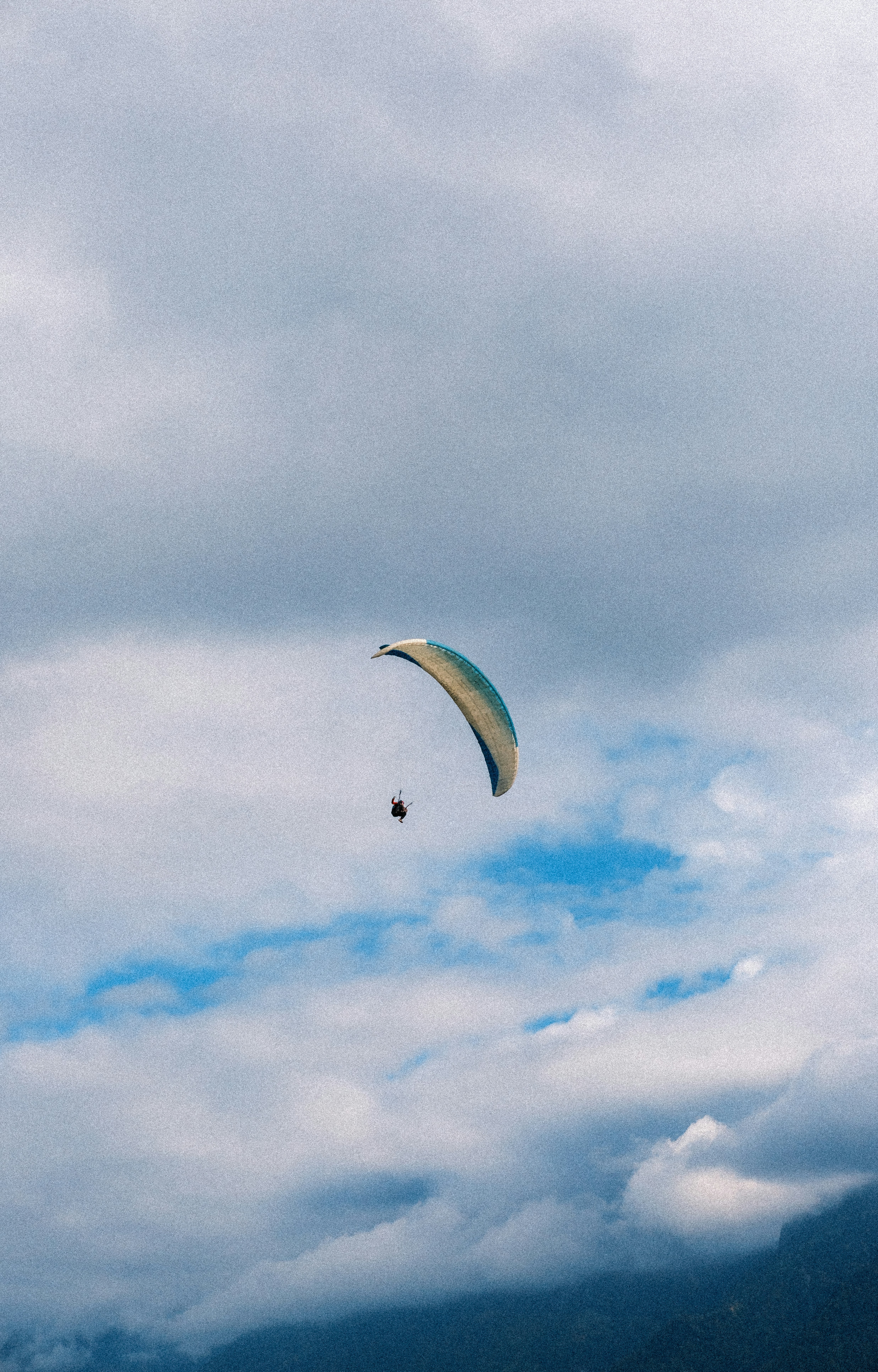 Soaring Silhouette: Paraglider Against a Vast Sky