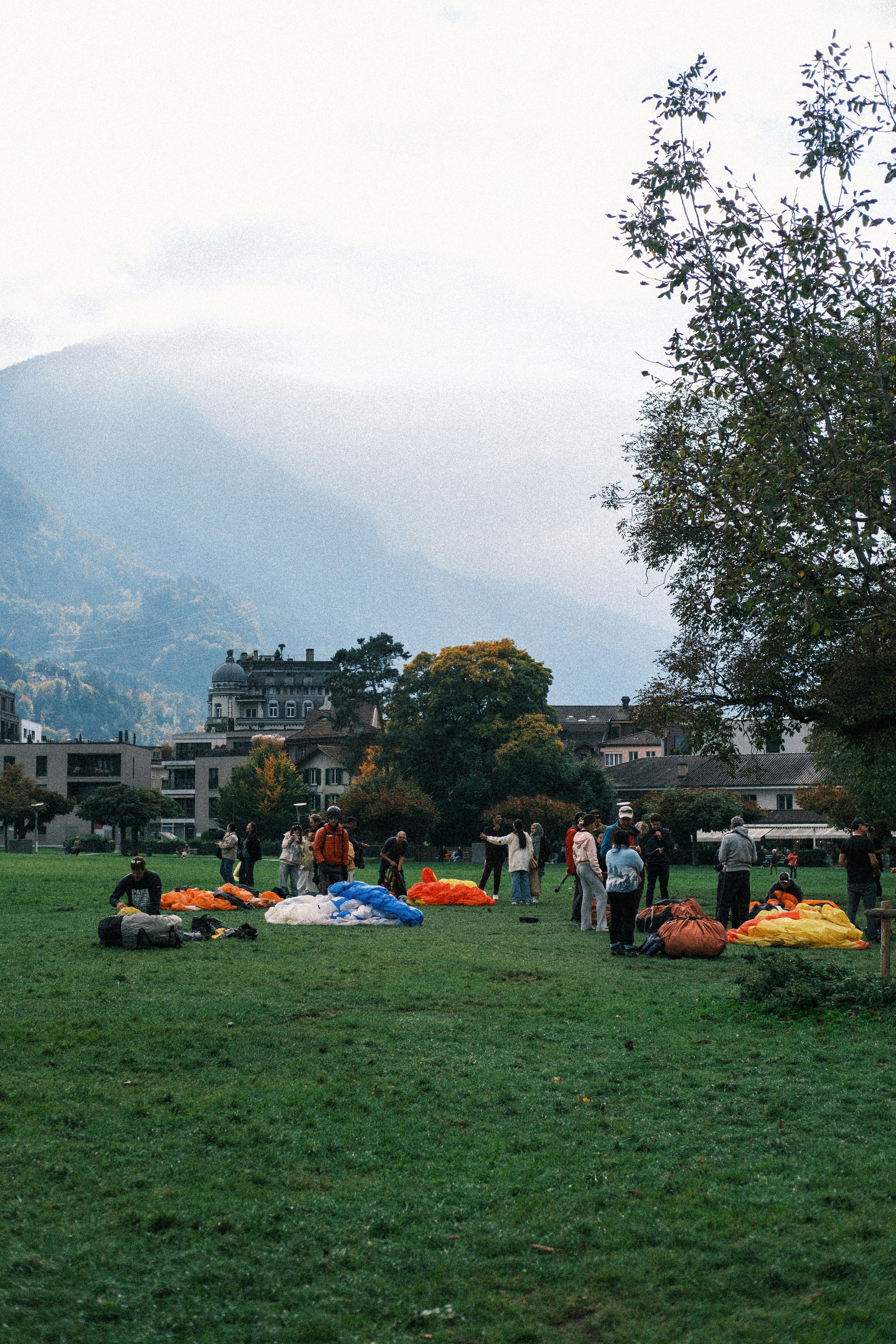 Parade of Colorful Parachutes in a Lush Park Amid a Mountain Town