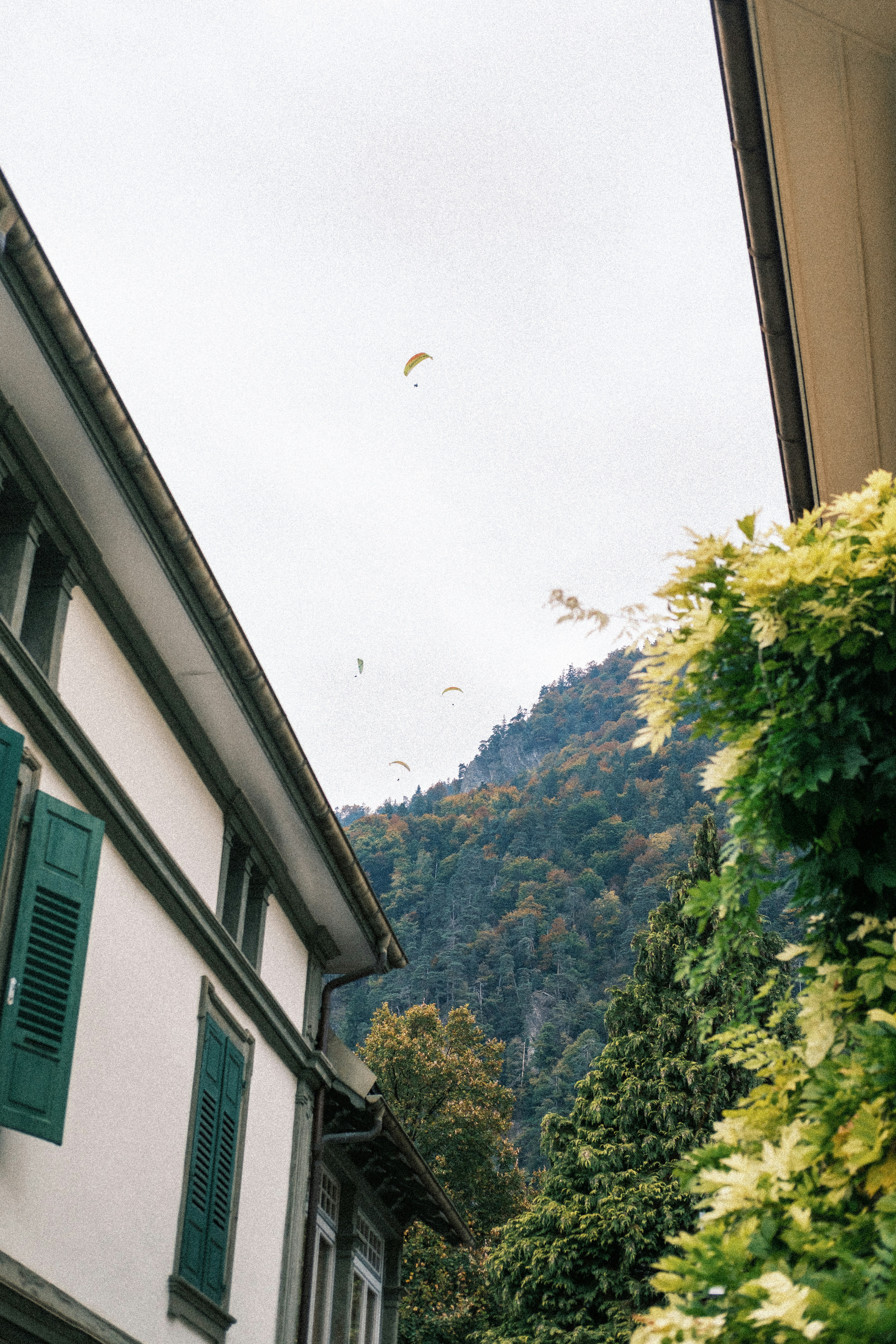 Paraglider Alley: Parachutes Dot the Sky Above a Quiet Terrace