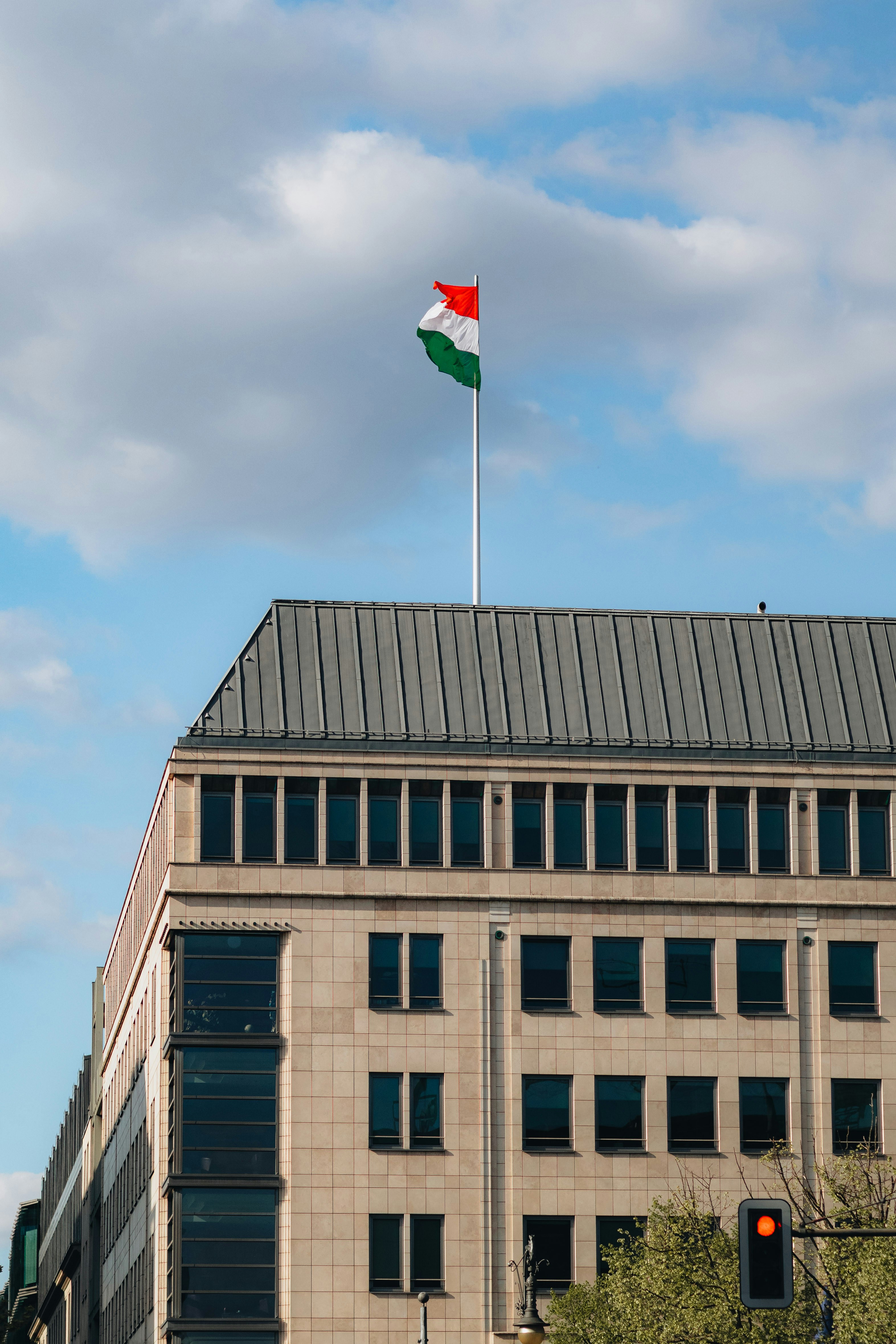 Flag atop the modern office block against a blue-sky canvas