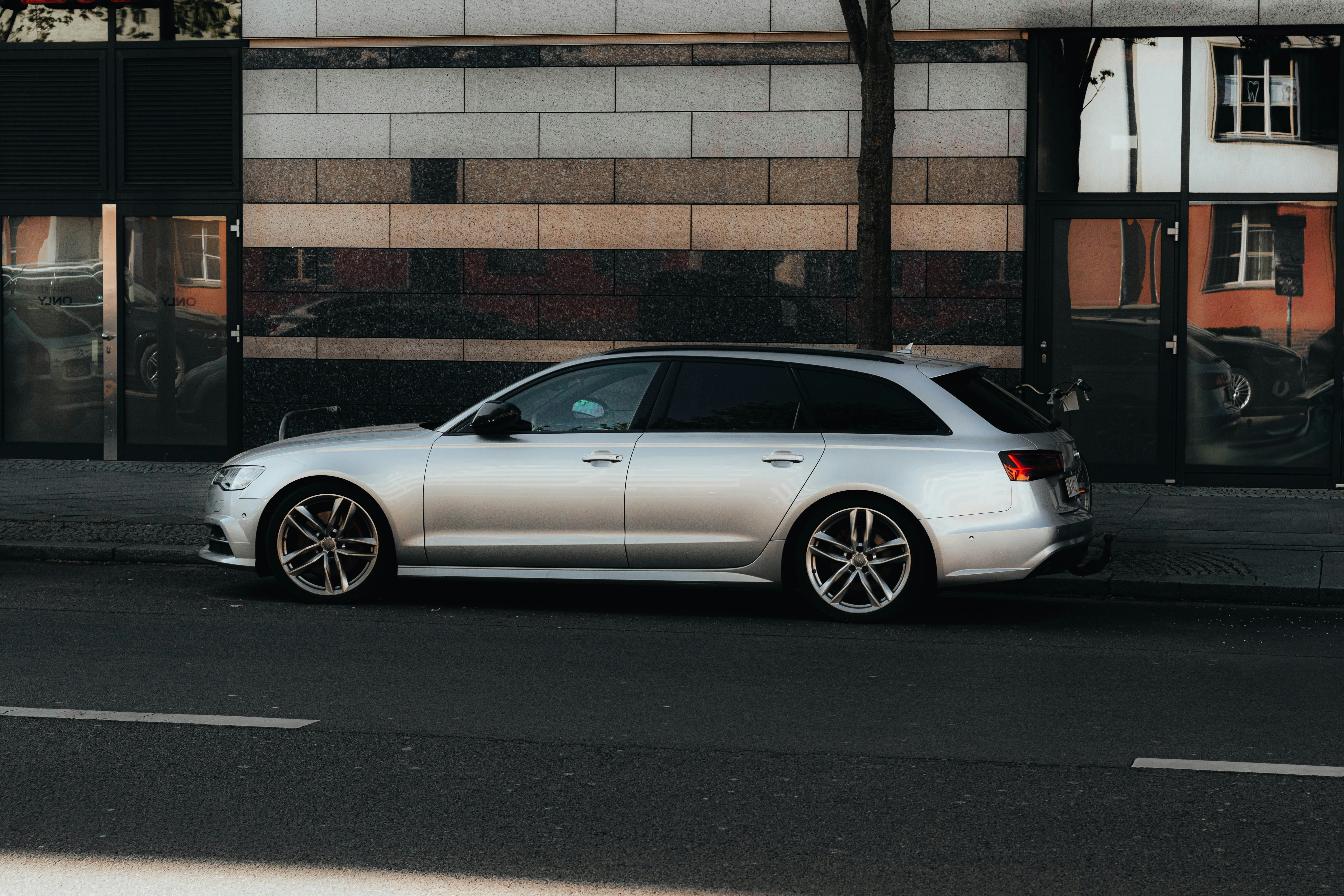 A silver station wagon parked on the street.