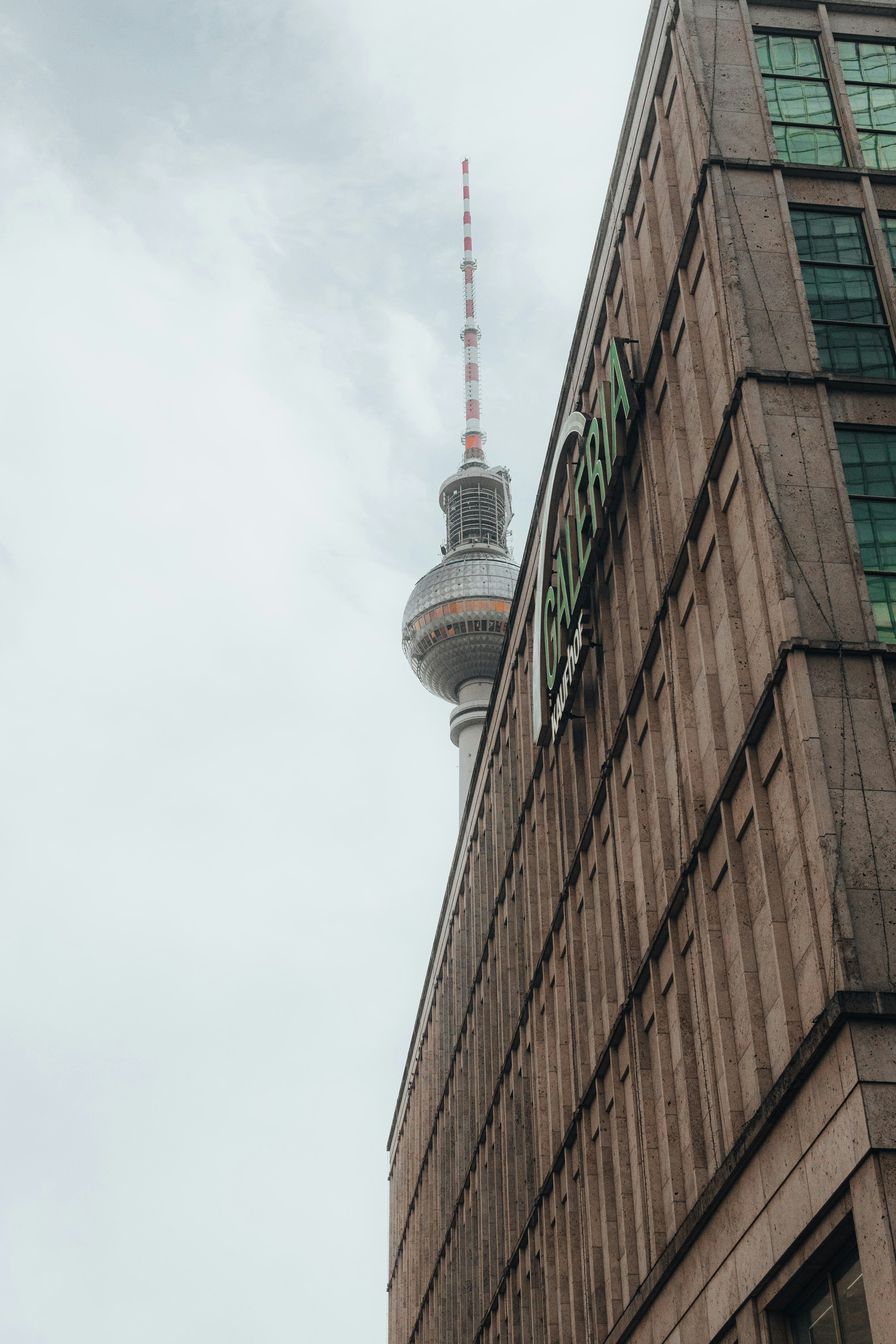 Urban Needle: Berlin TV Tower Rising beside a Corporate Facade