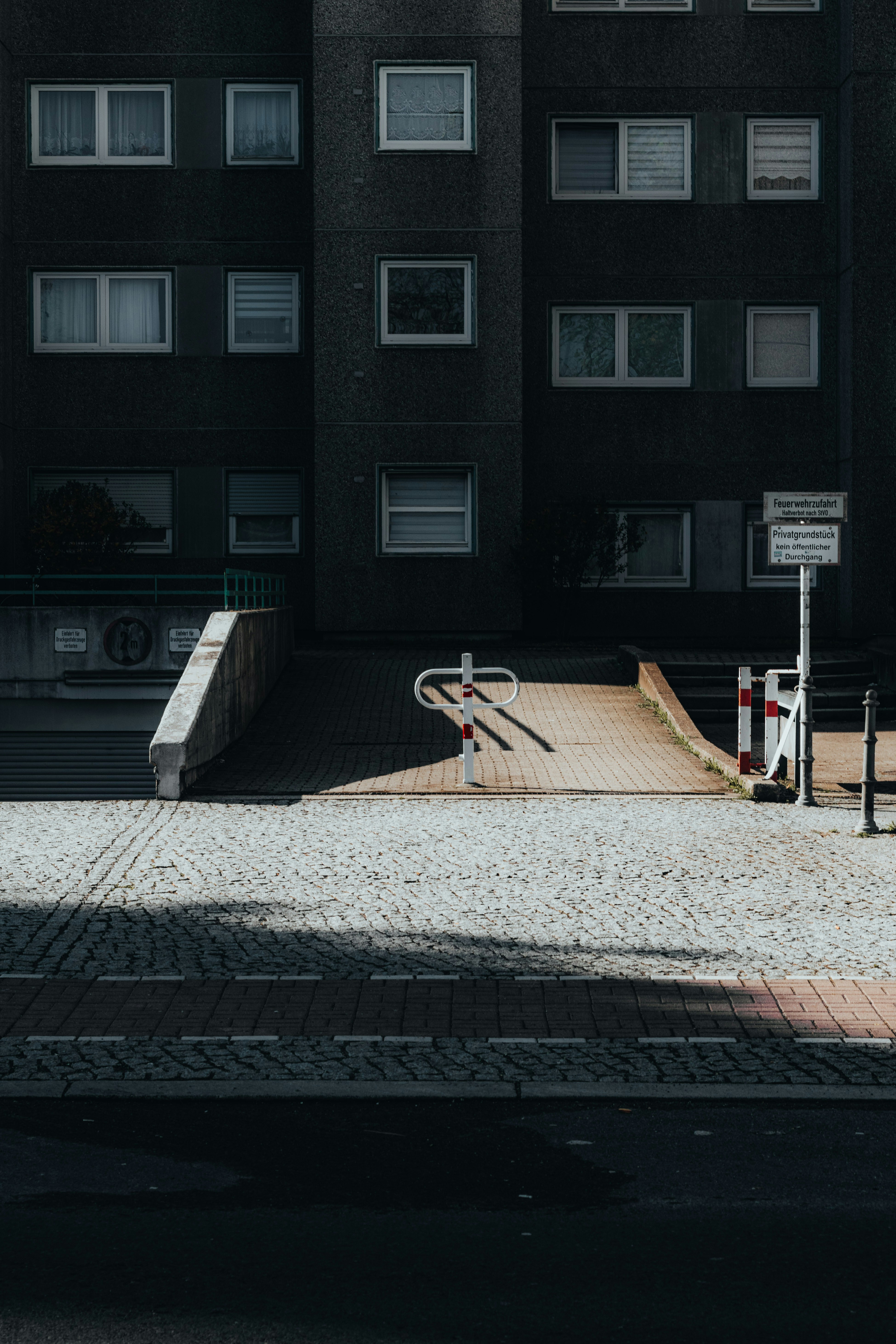 Urban Threshold: Shadowed Courtyard Beneath a Concrete Facade