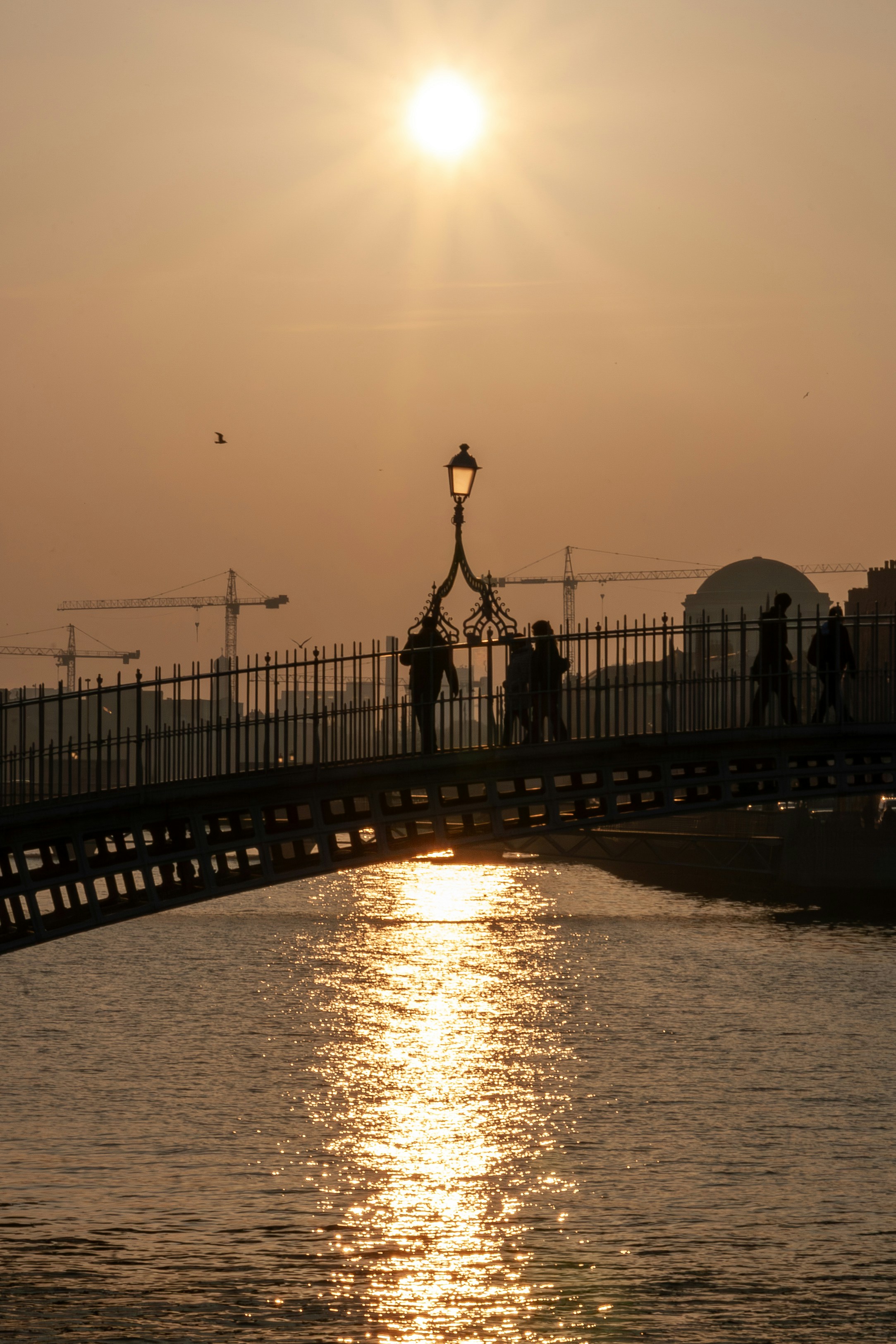 Sunlit silhouette on the bridge: silhouettes and lantern in the golden hour