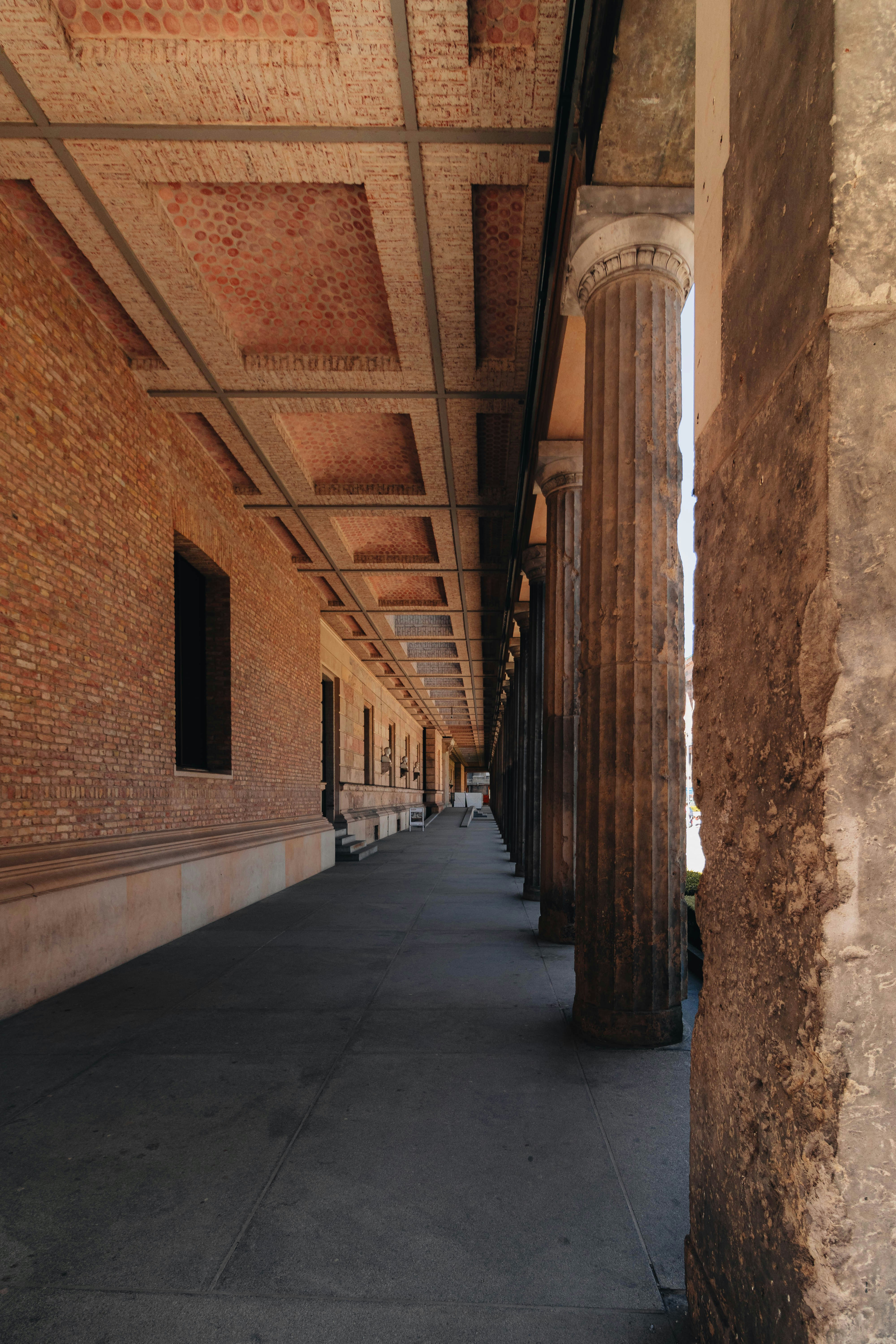 Columns in Quiet Perimeter: A Long Corridor Under Brick and Stone