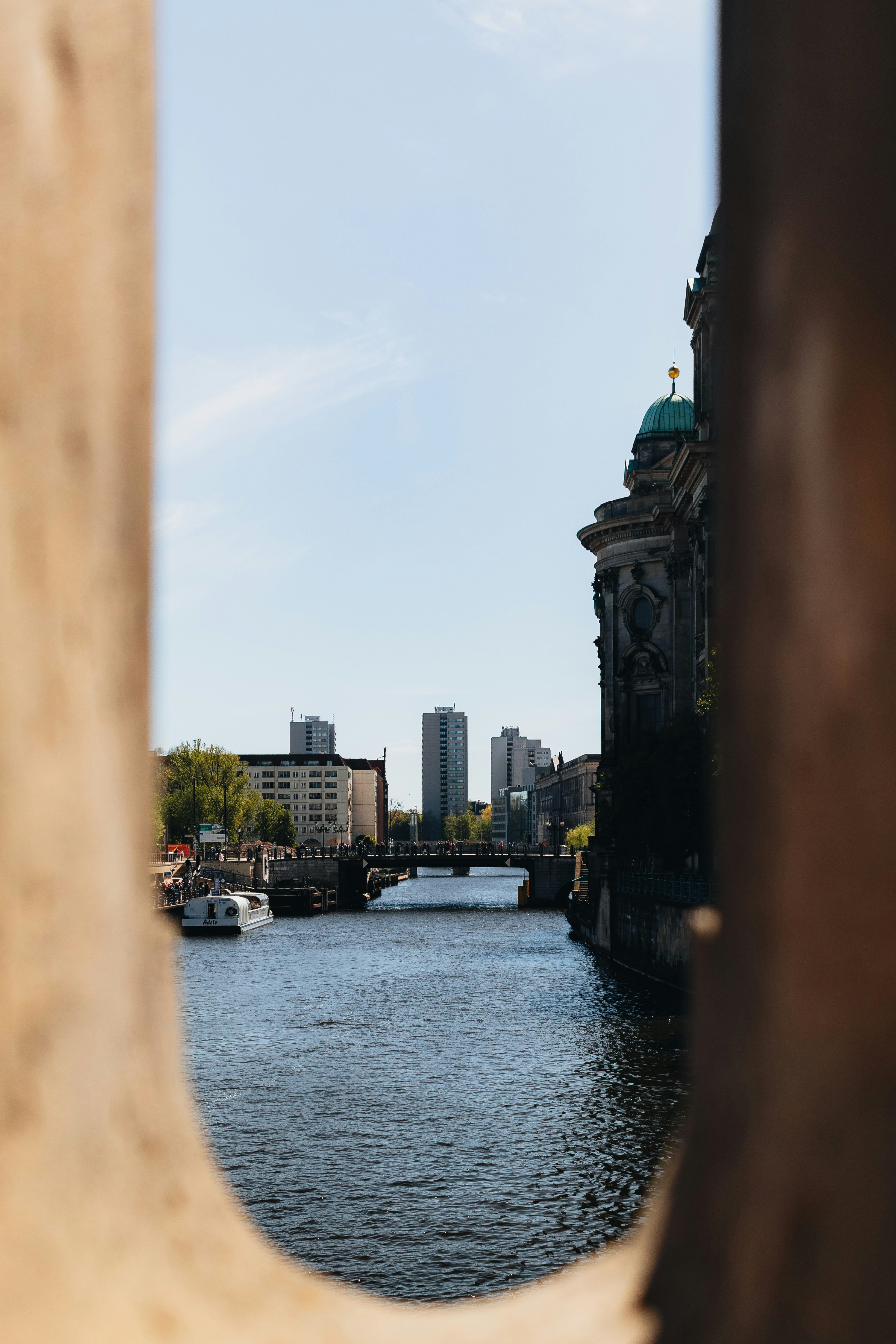 Waterway Through a Historic Arch Between City Horizons