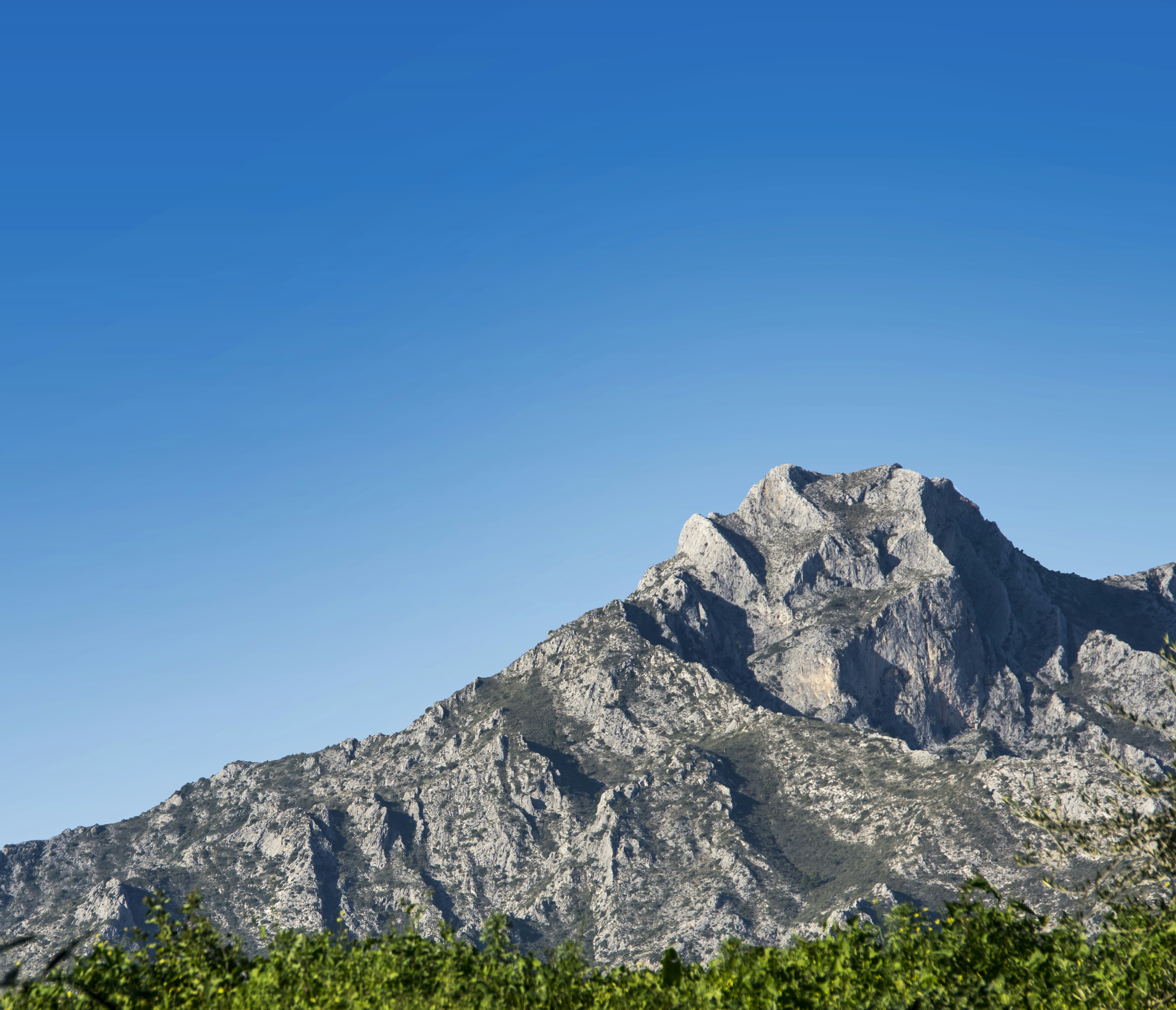 Stone Crown: Sunlit Peak Over a Quiet Green Prairie