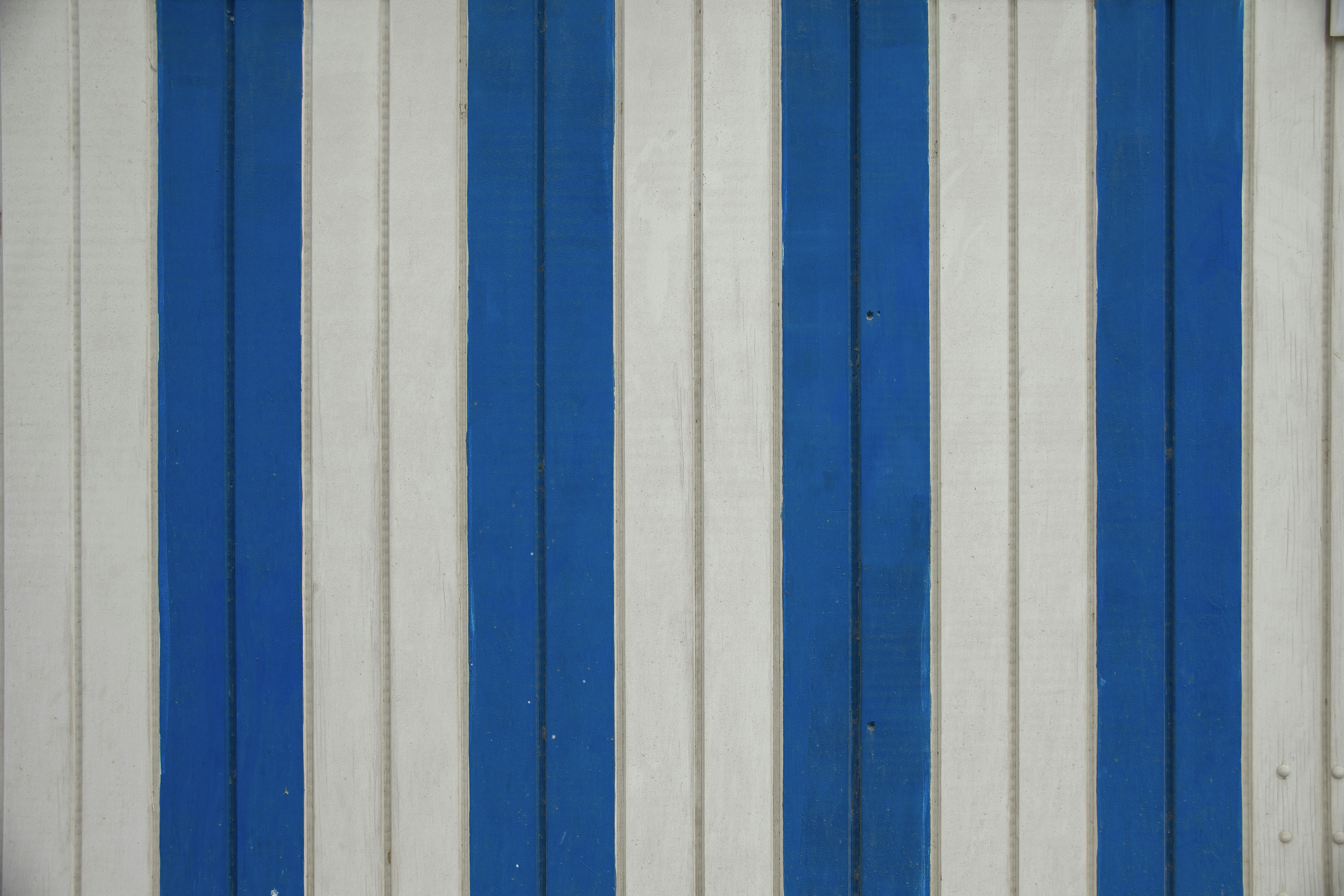 Vertical Stripes in Blue and White: A Rhythm of Color on a Facade