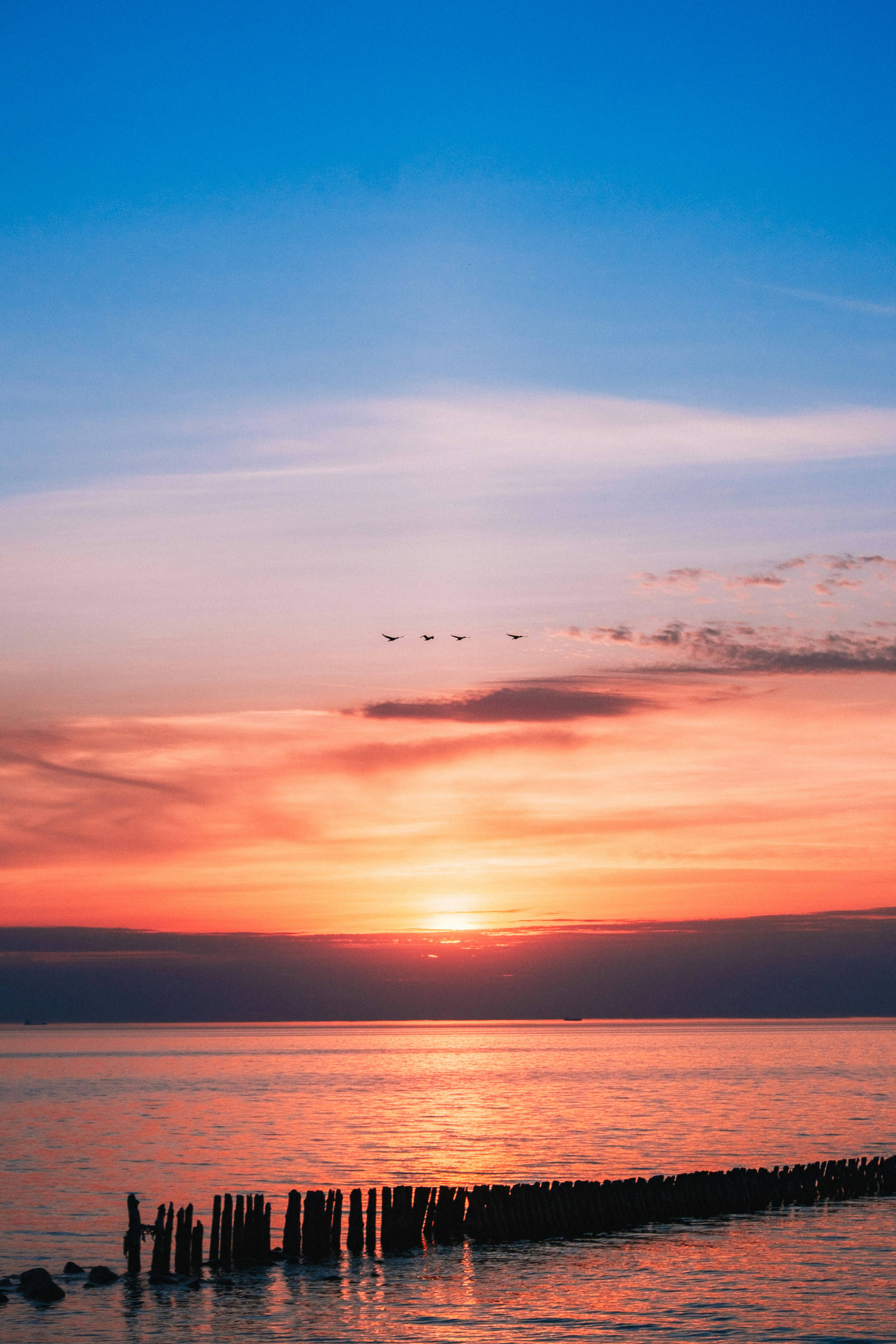 Horizon Fire: A Serene Sunset over Weathered Piers