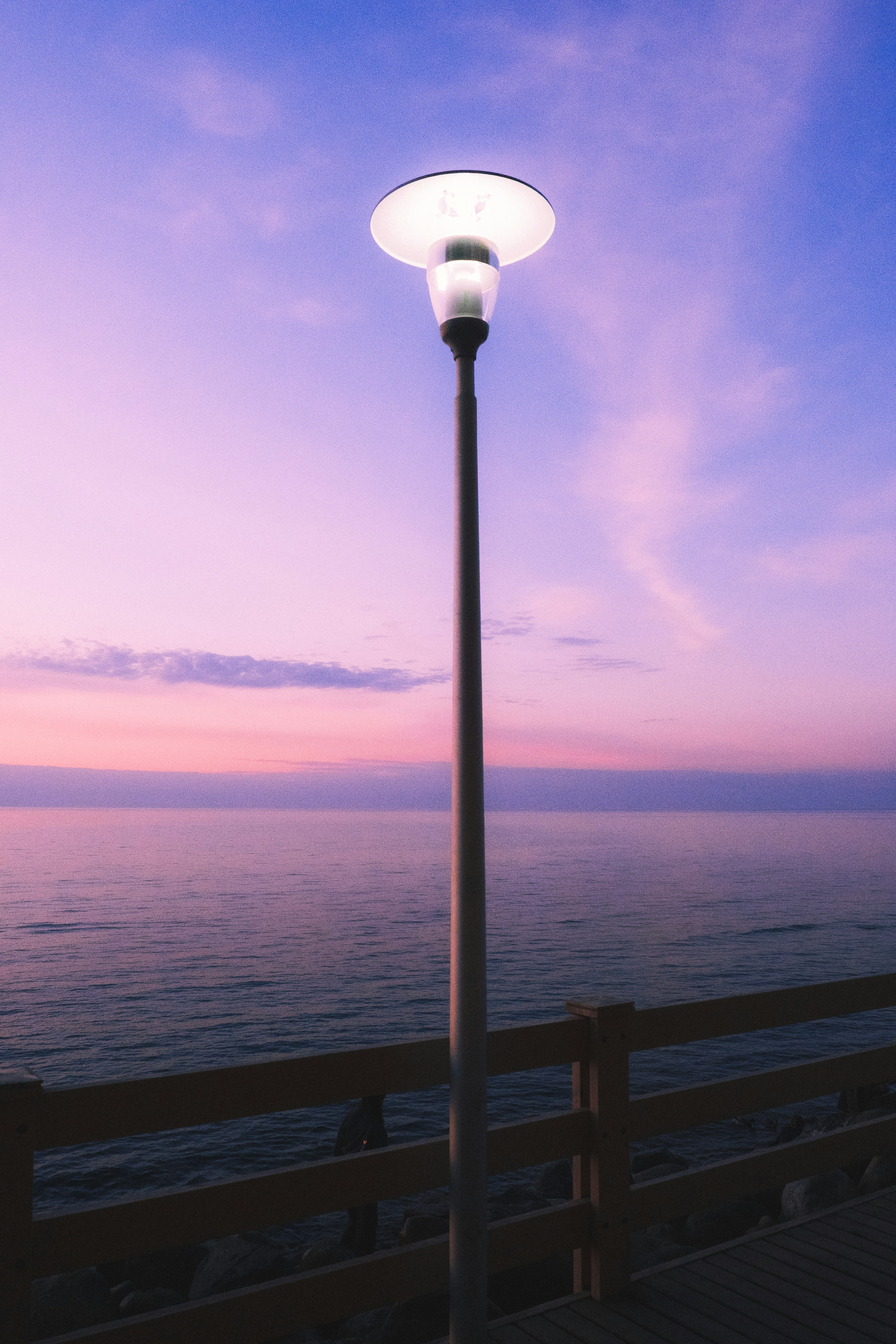 Evening Beacon: a solitary streetlamp over pastel sea