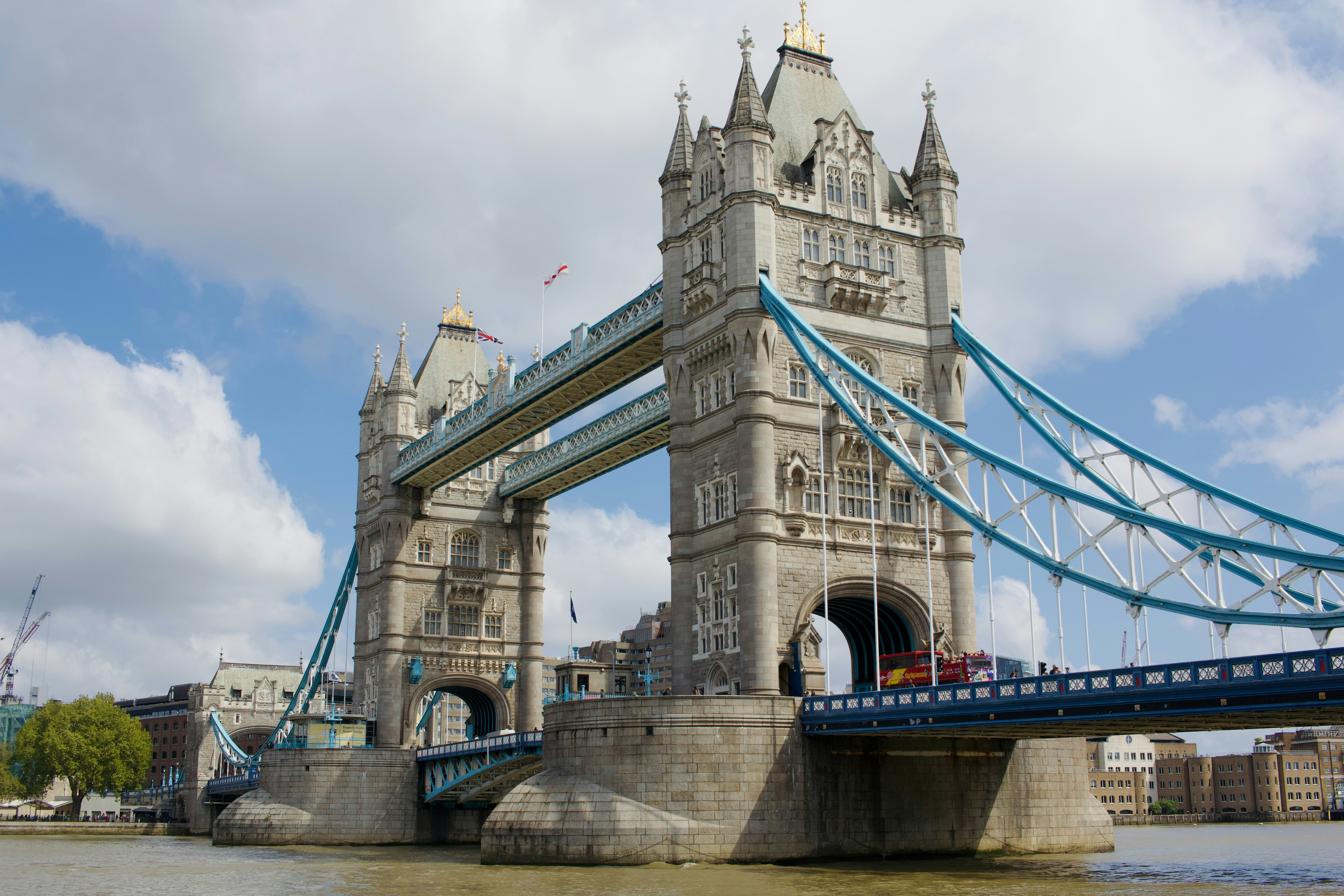 Tower Bridge under a bright sky: blue suspension cables framing the Thames