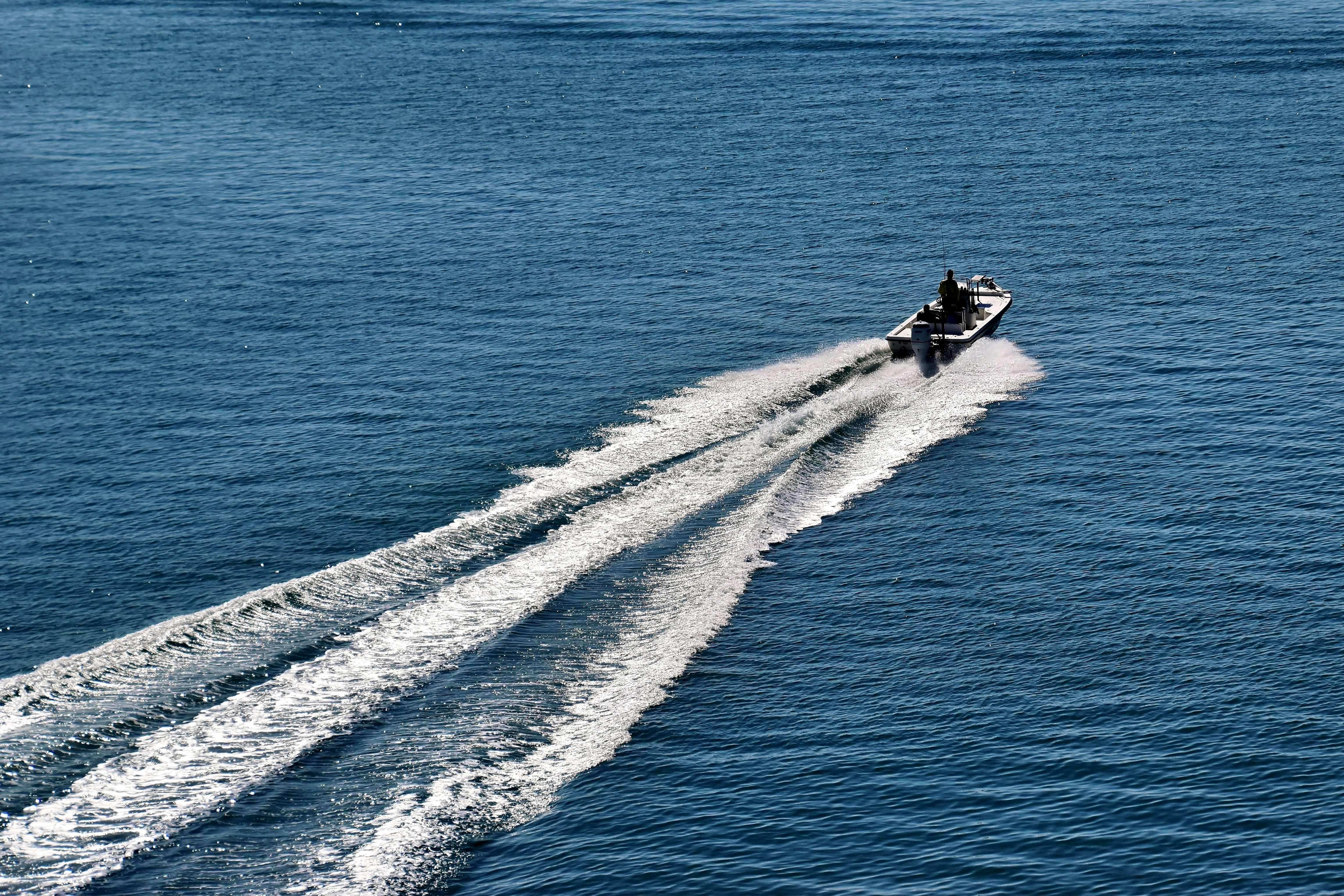 High-Speed Blue: A Boat Carves Clean Lines Across Open Water