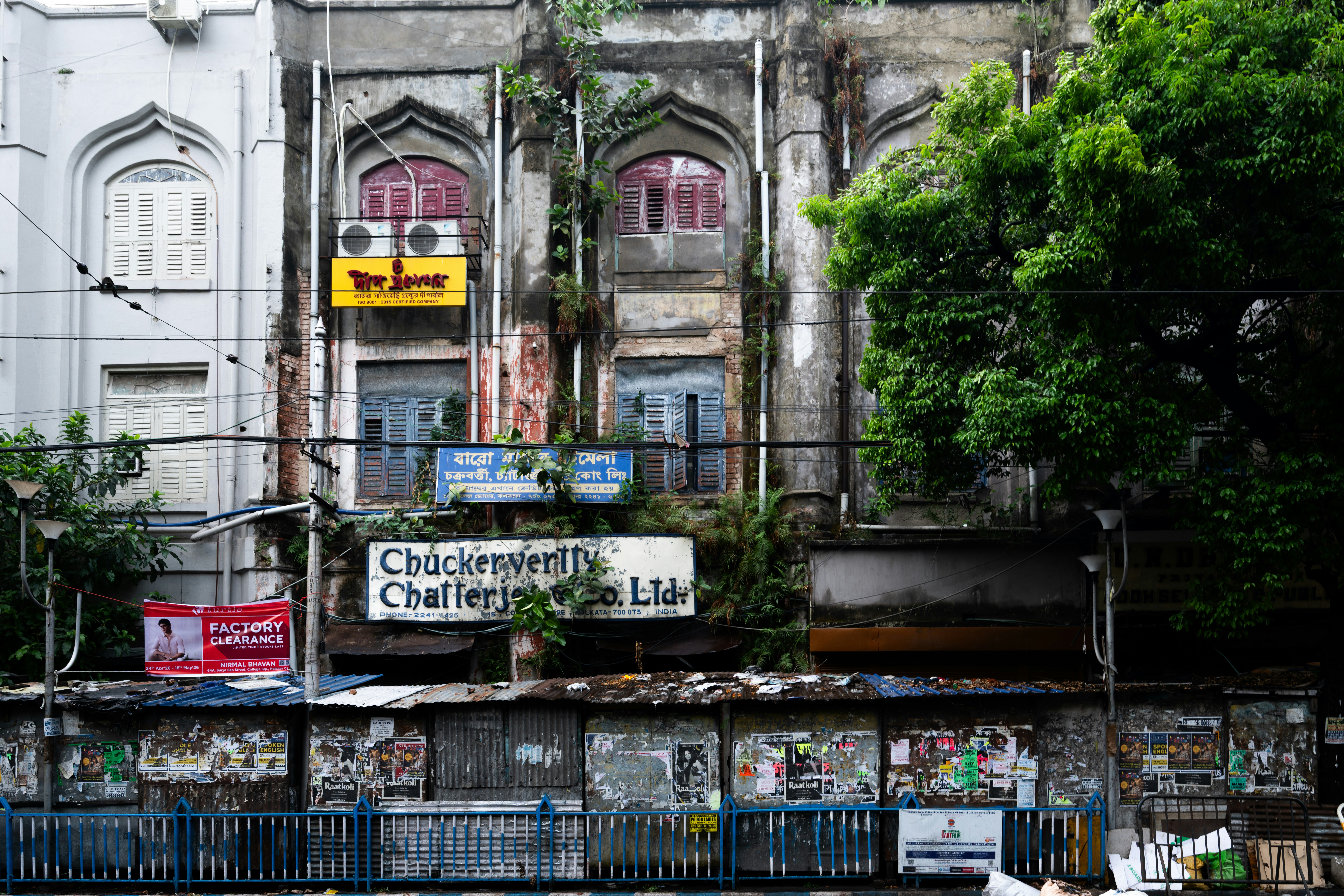Concrete Facade and Colorful Shuttered Windows: A Weathered Urban Balcony Scene