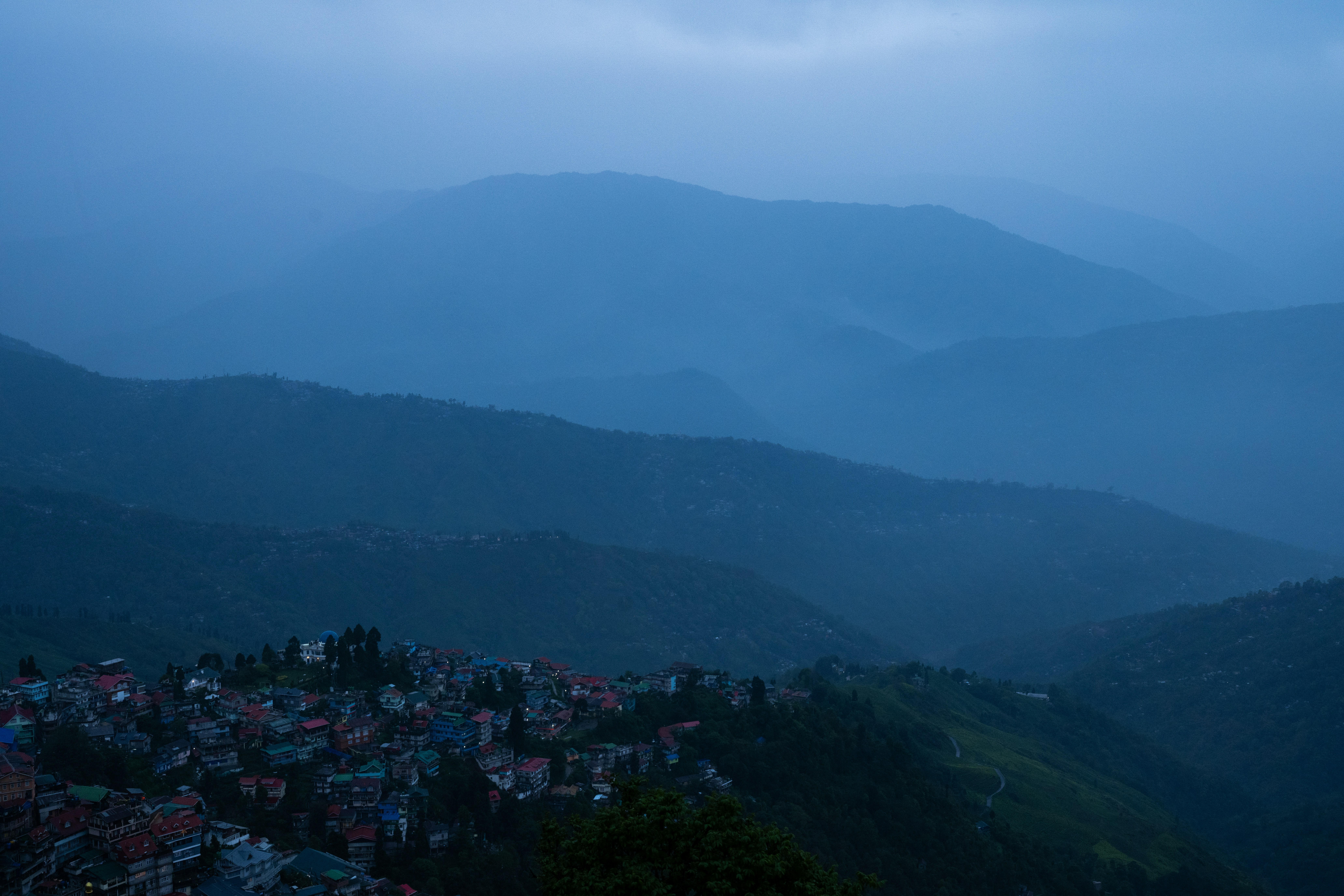 Misty blue mountains with a village below