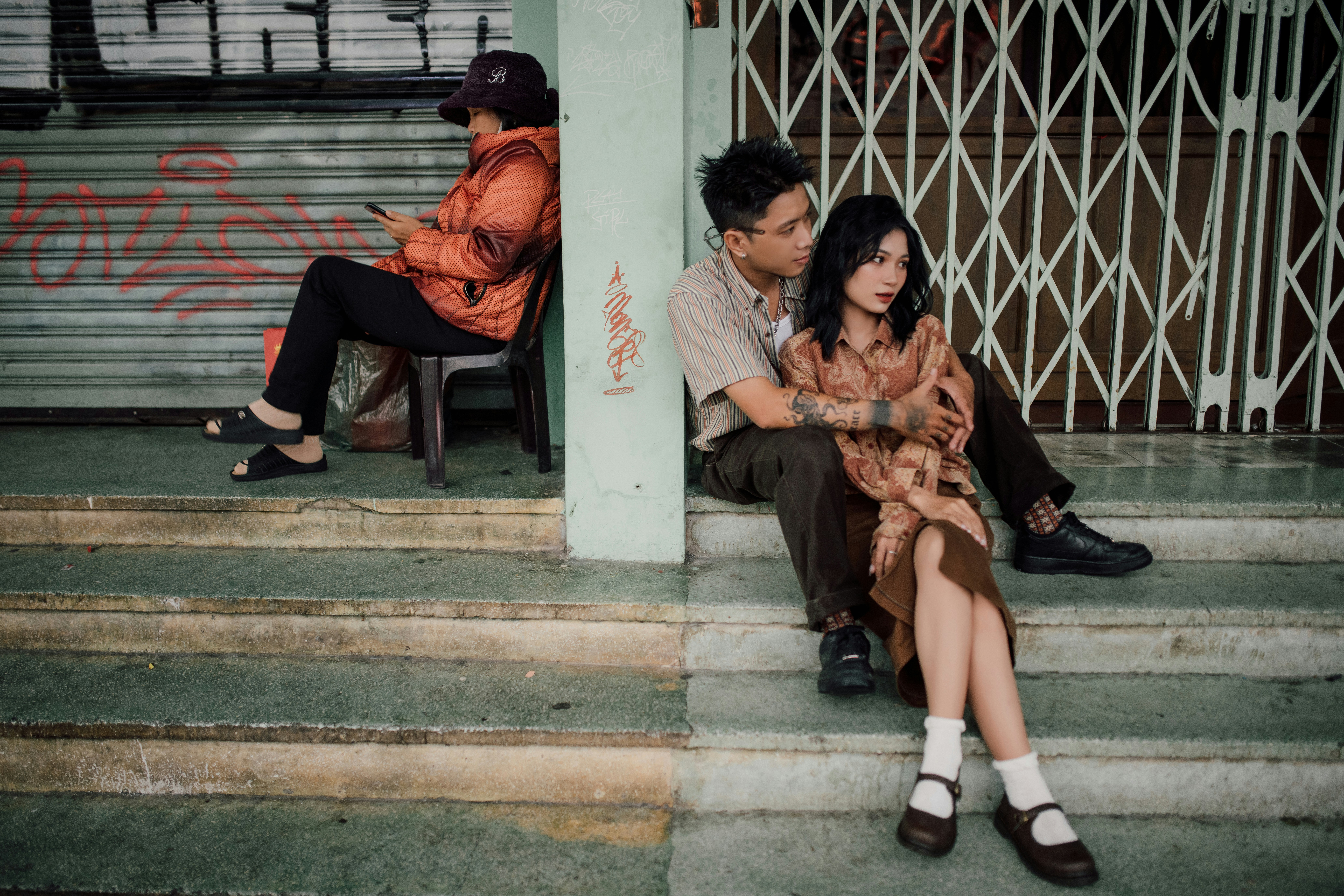 Muted Urban Quiet: A Couple on Steps with a Distant Stranger