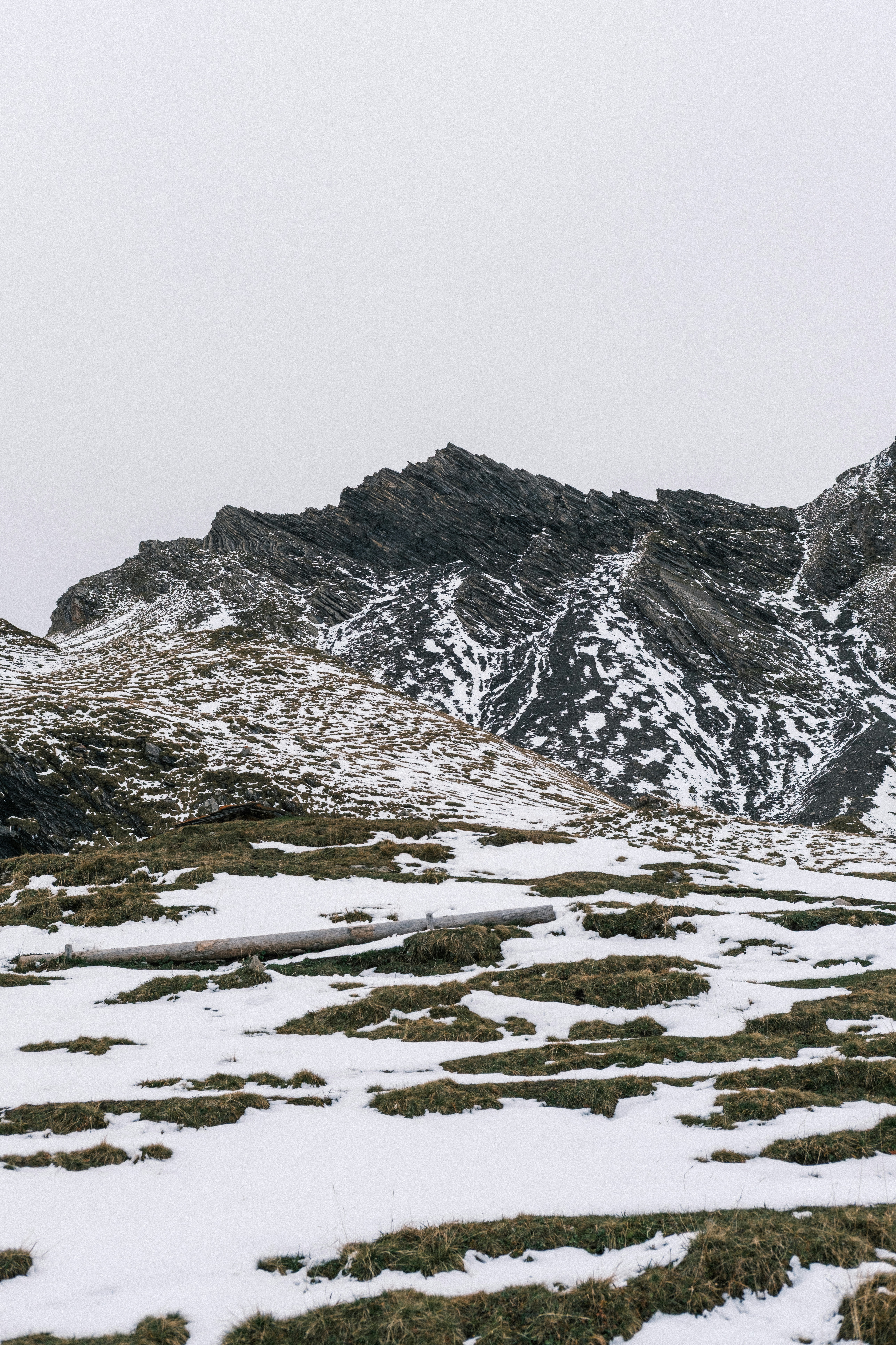 Snow-kissed Ridge Under Quiet Overcast Sky