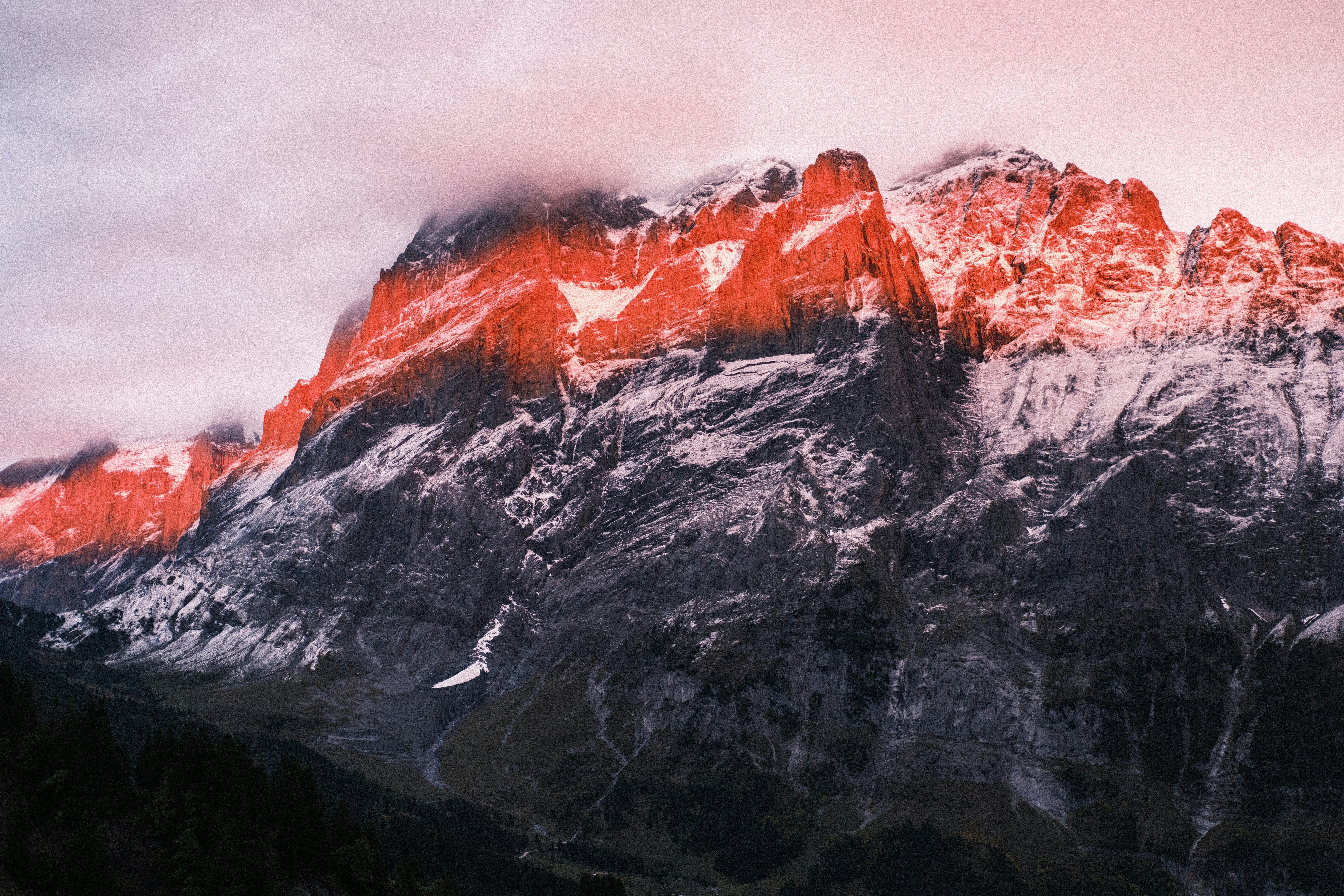 Pink-tinted dawn over sculpted alpine peaks