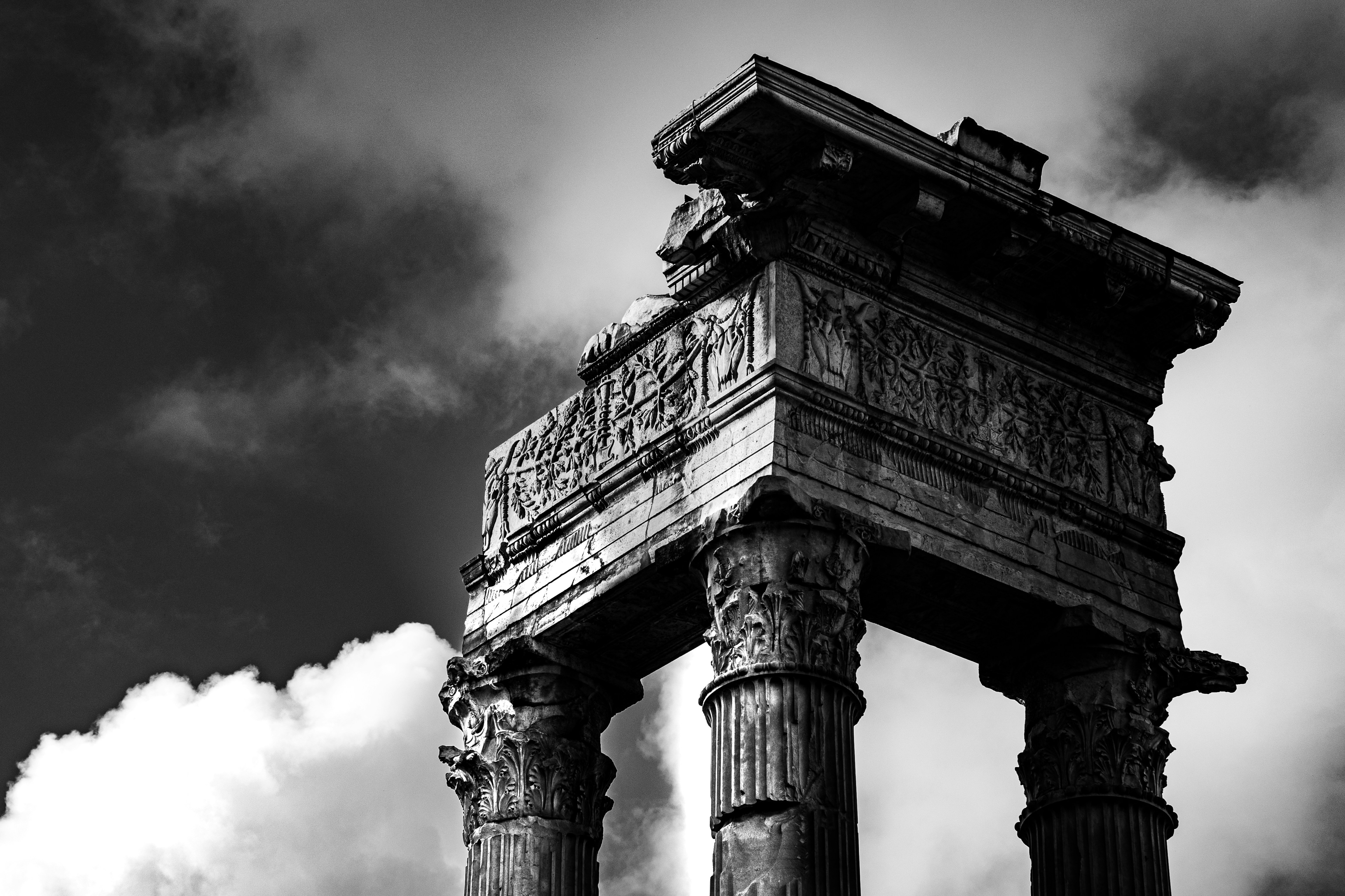 Ancient Gateways: Carved columns Reach Toward a Stormy Sky