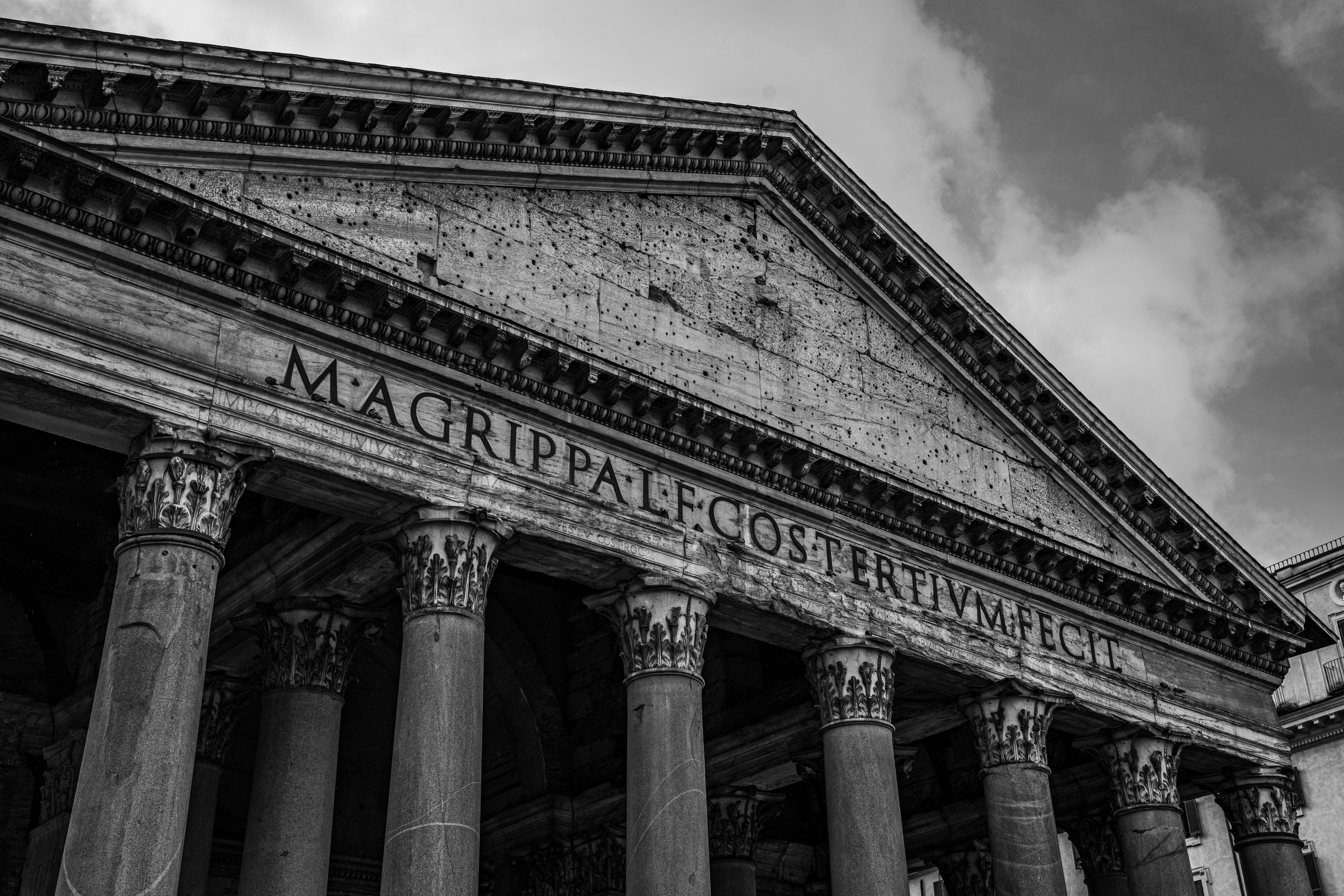Majestic Roman Facade: Weathered Columns and Inscribed Pediment