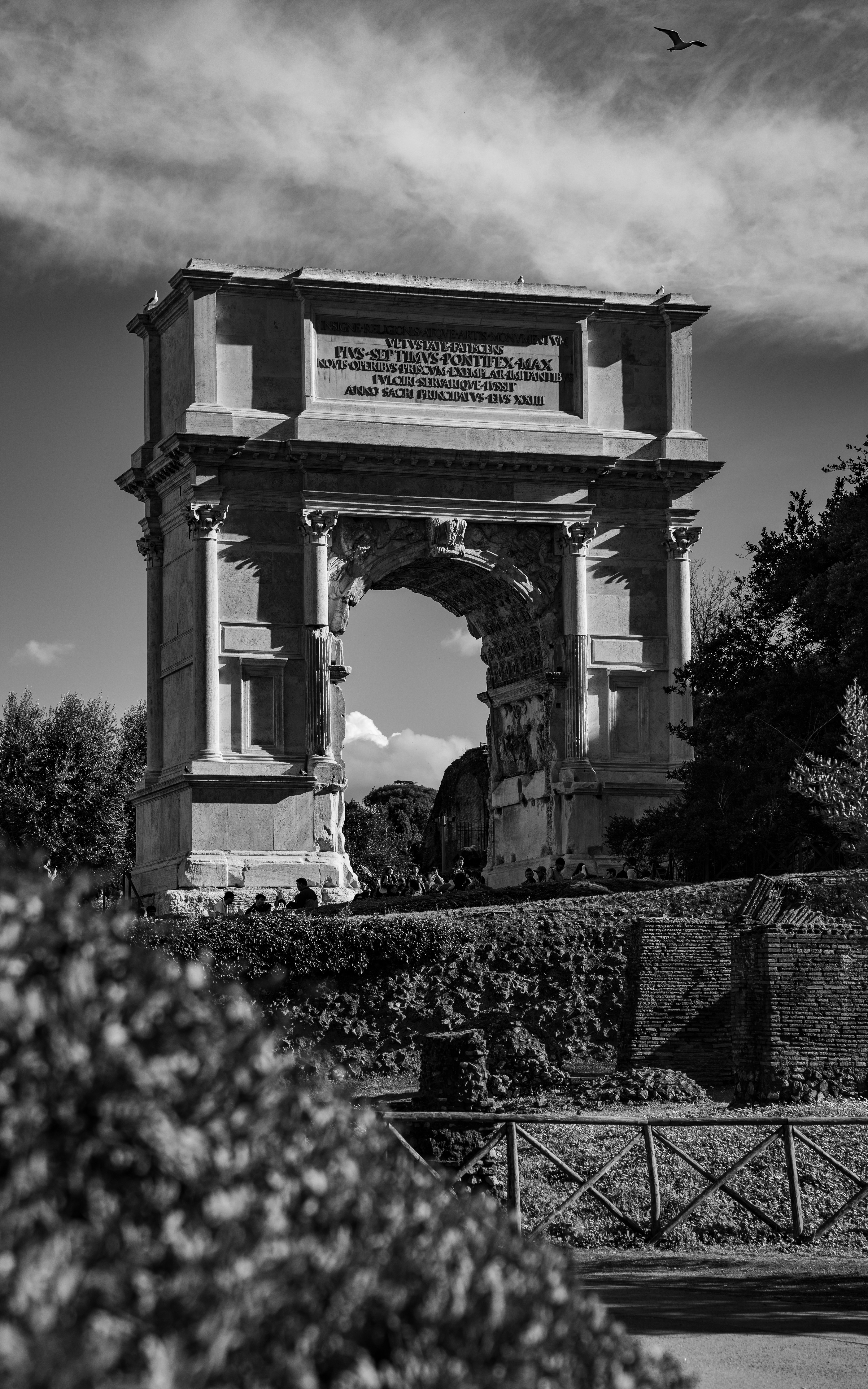 Ancient roman archway with inscription and cloudy sky