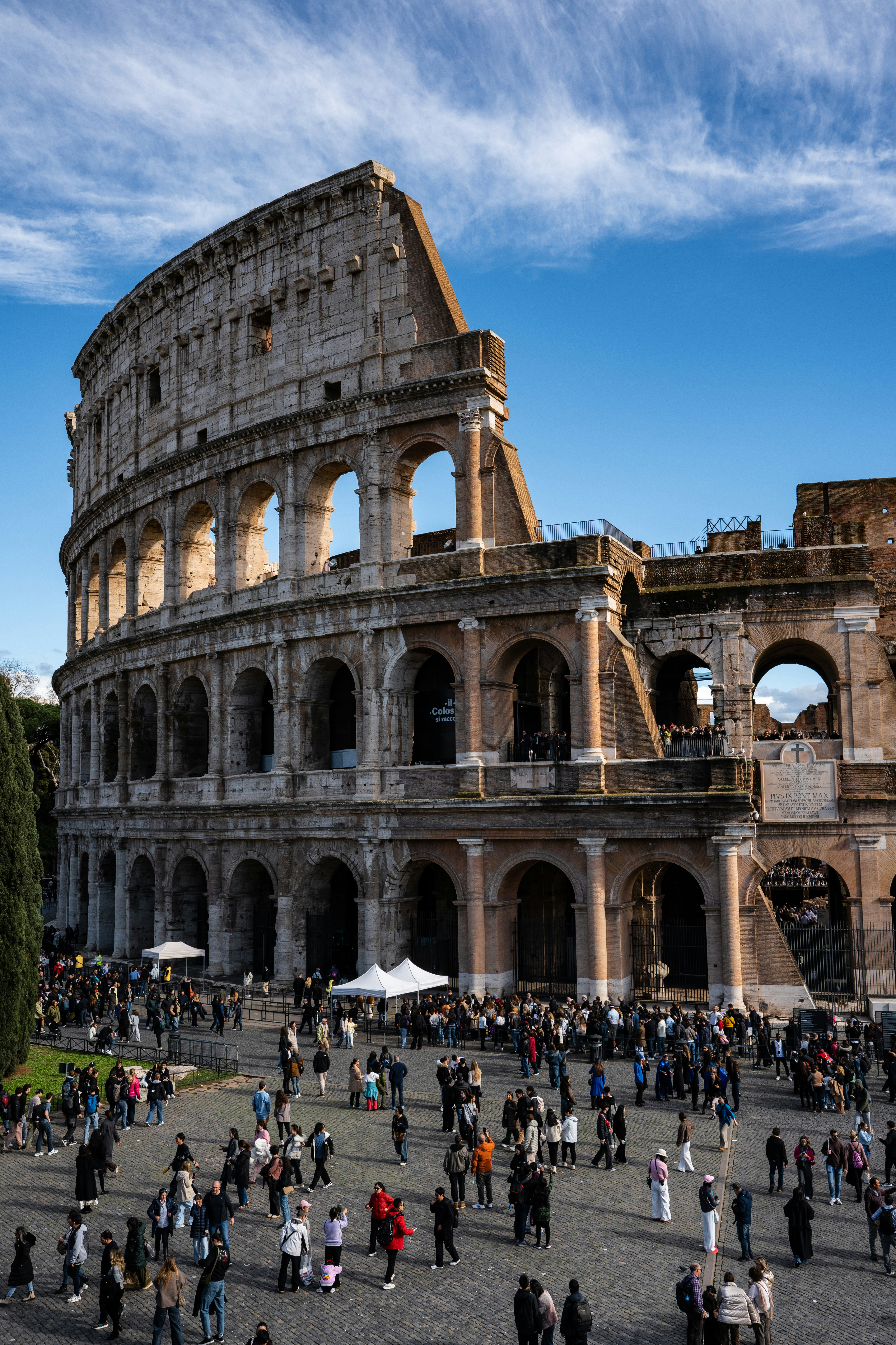 Colosseum crowds at the apex of stone arches bathed in afternoon light