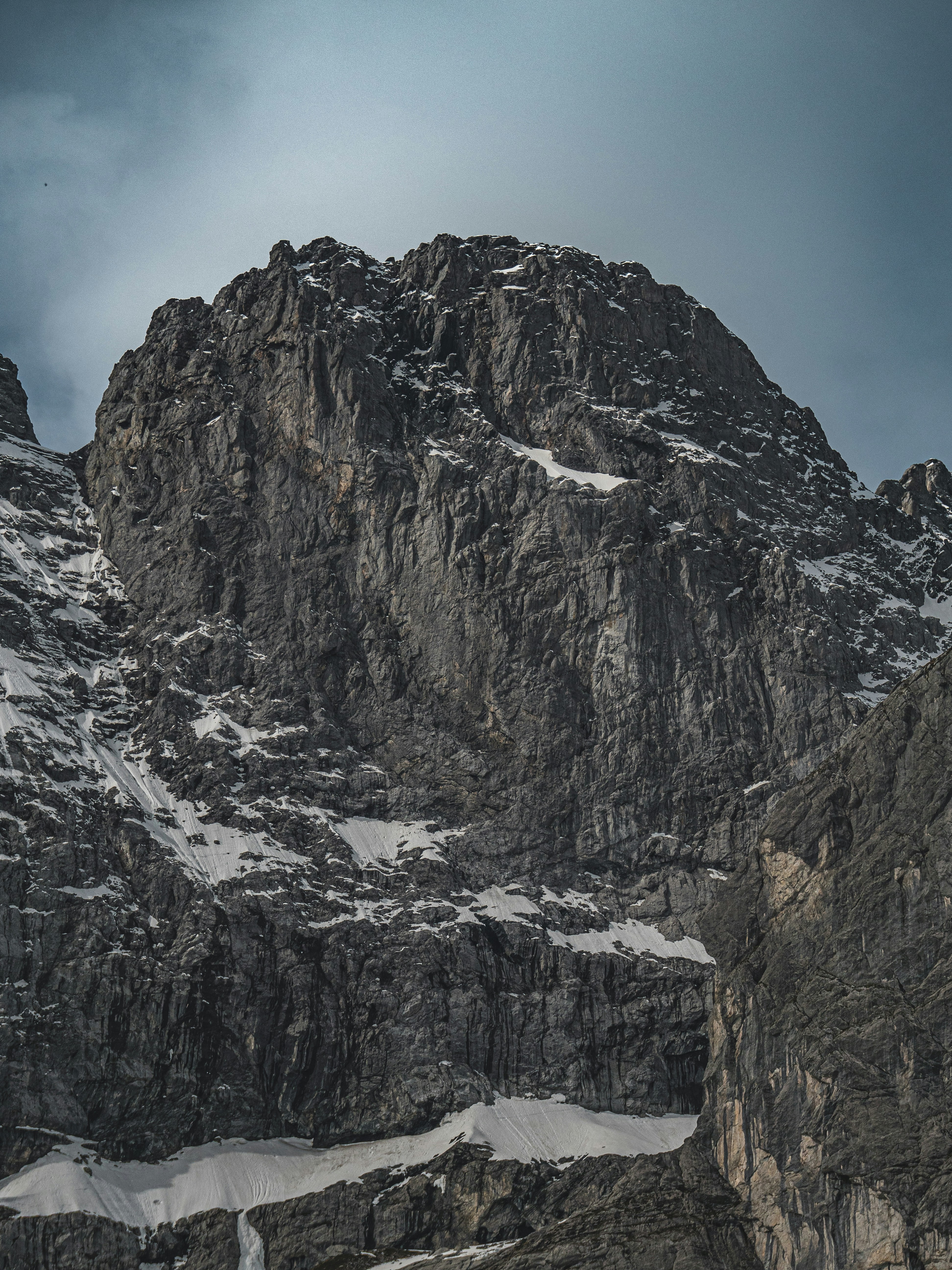 Crag Crown: A Snow-veiled Peak Rising into a Pale Sky