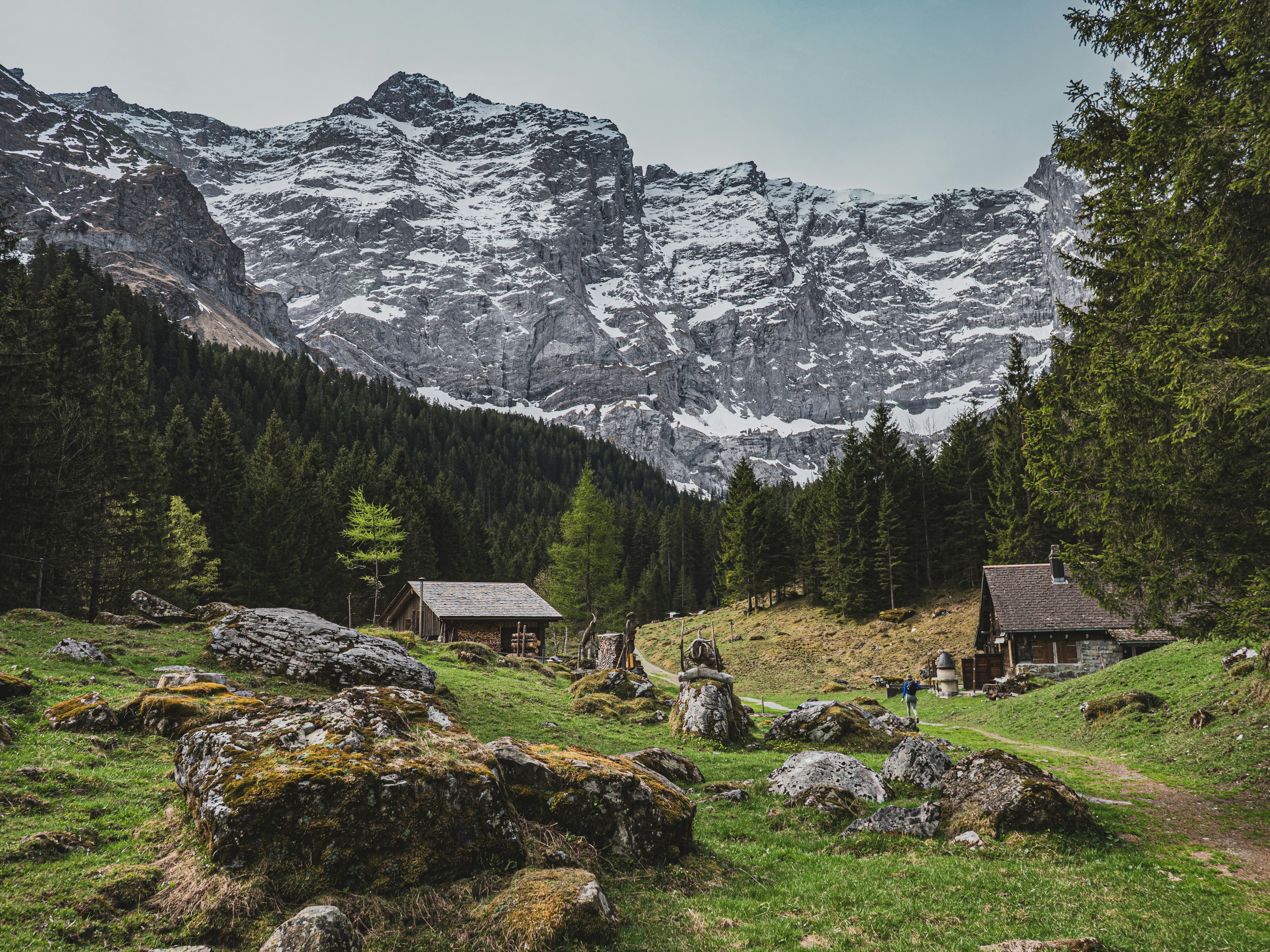 Stone cottages beneath snow-kissed peaks in a alpine meadow