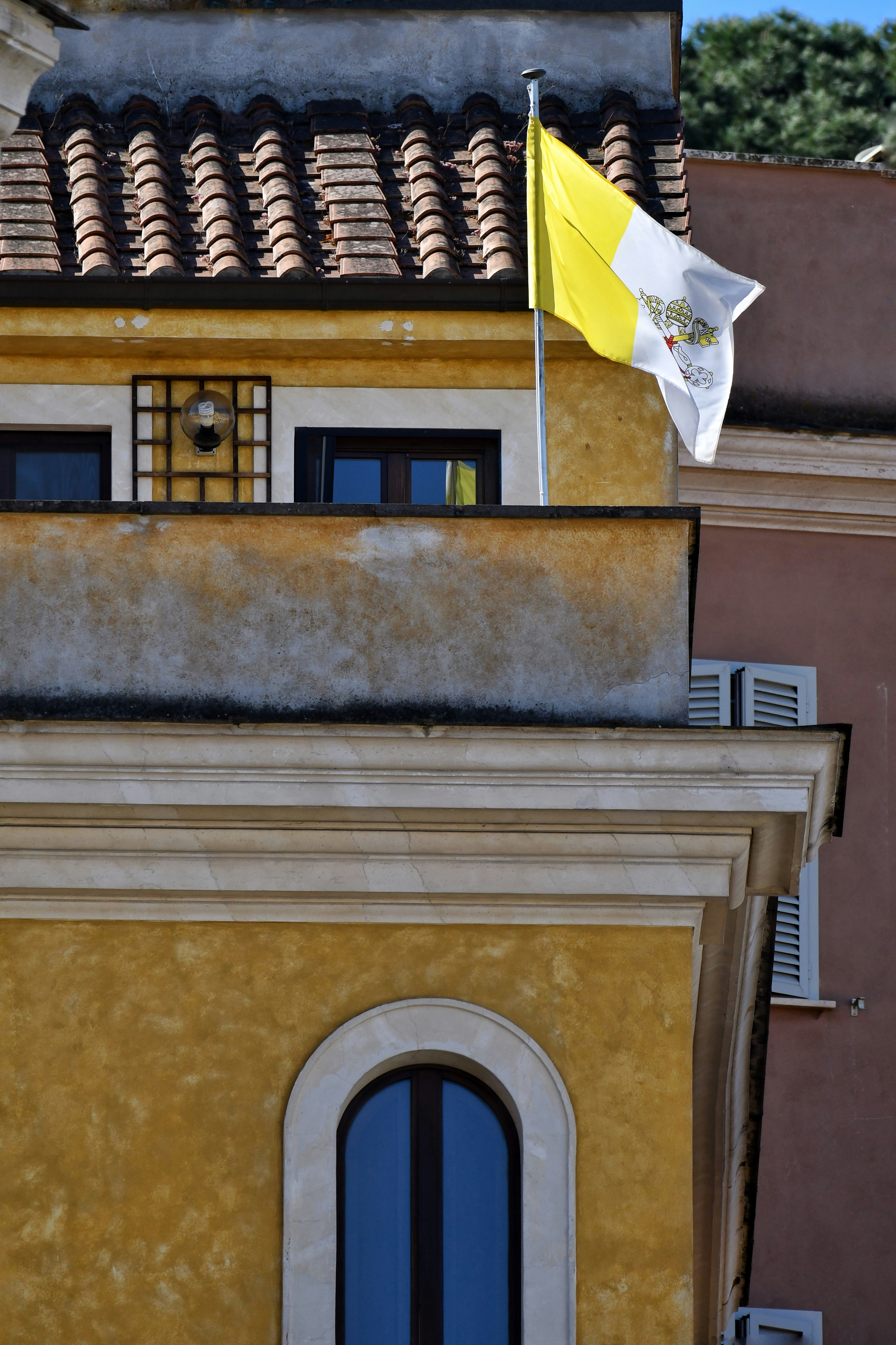 Yellow-and-White Flag Above a Sunlit Façade
