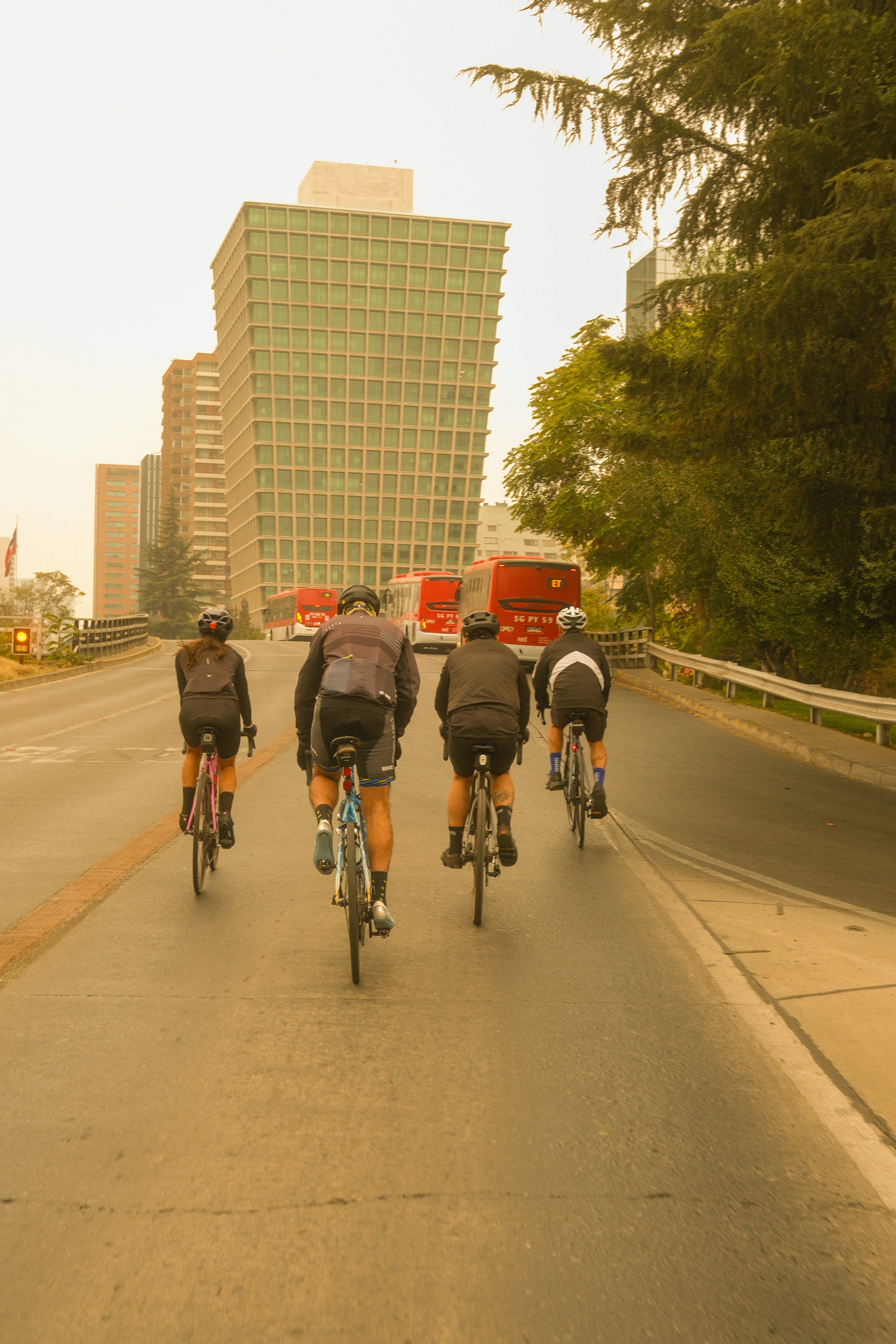 Four Cyclists Push Through a Modern City Boulevard