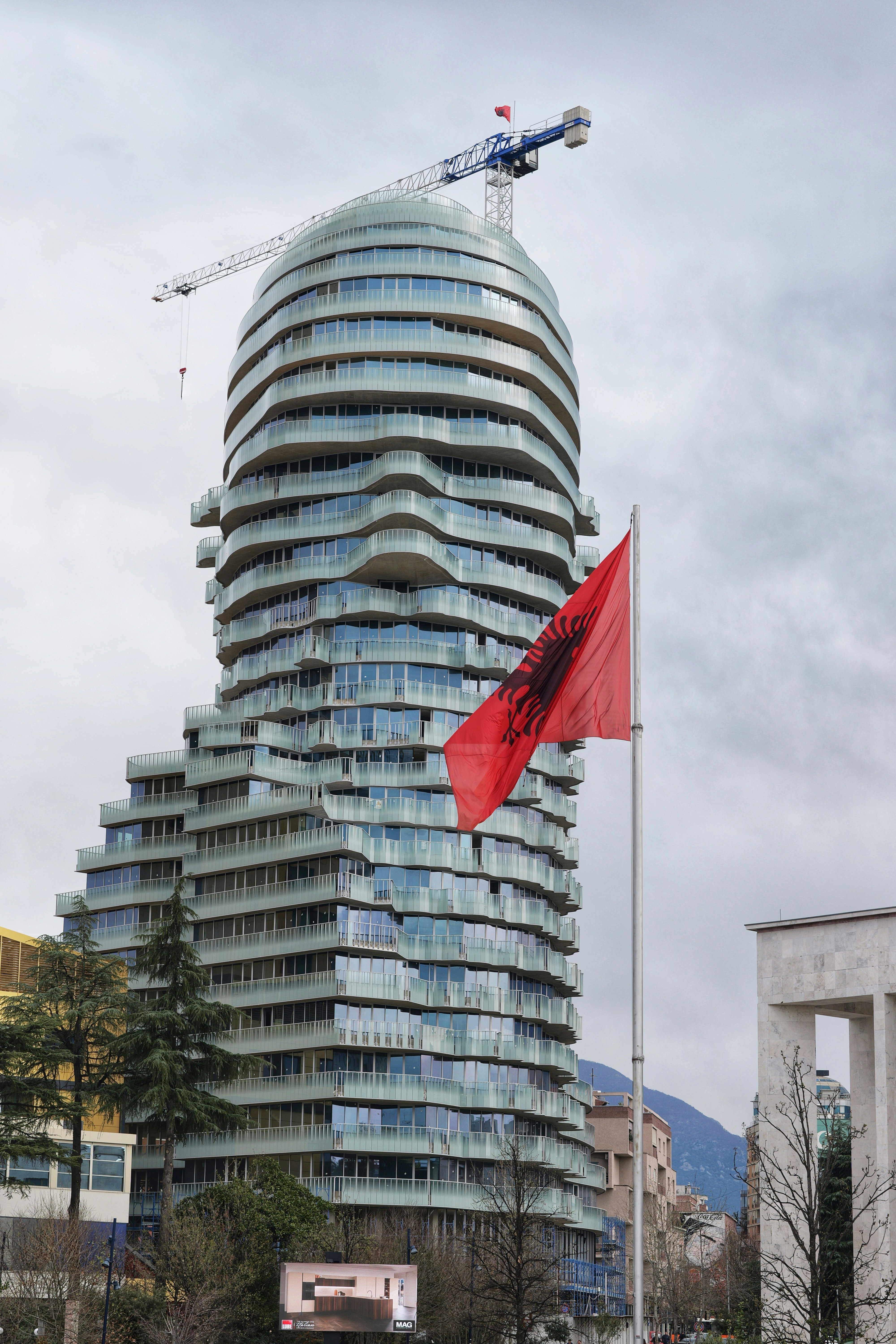 Tower Crane Sentinel over a Spiraled Glass Colossus