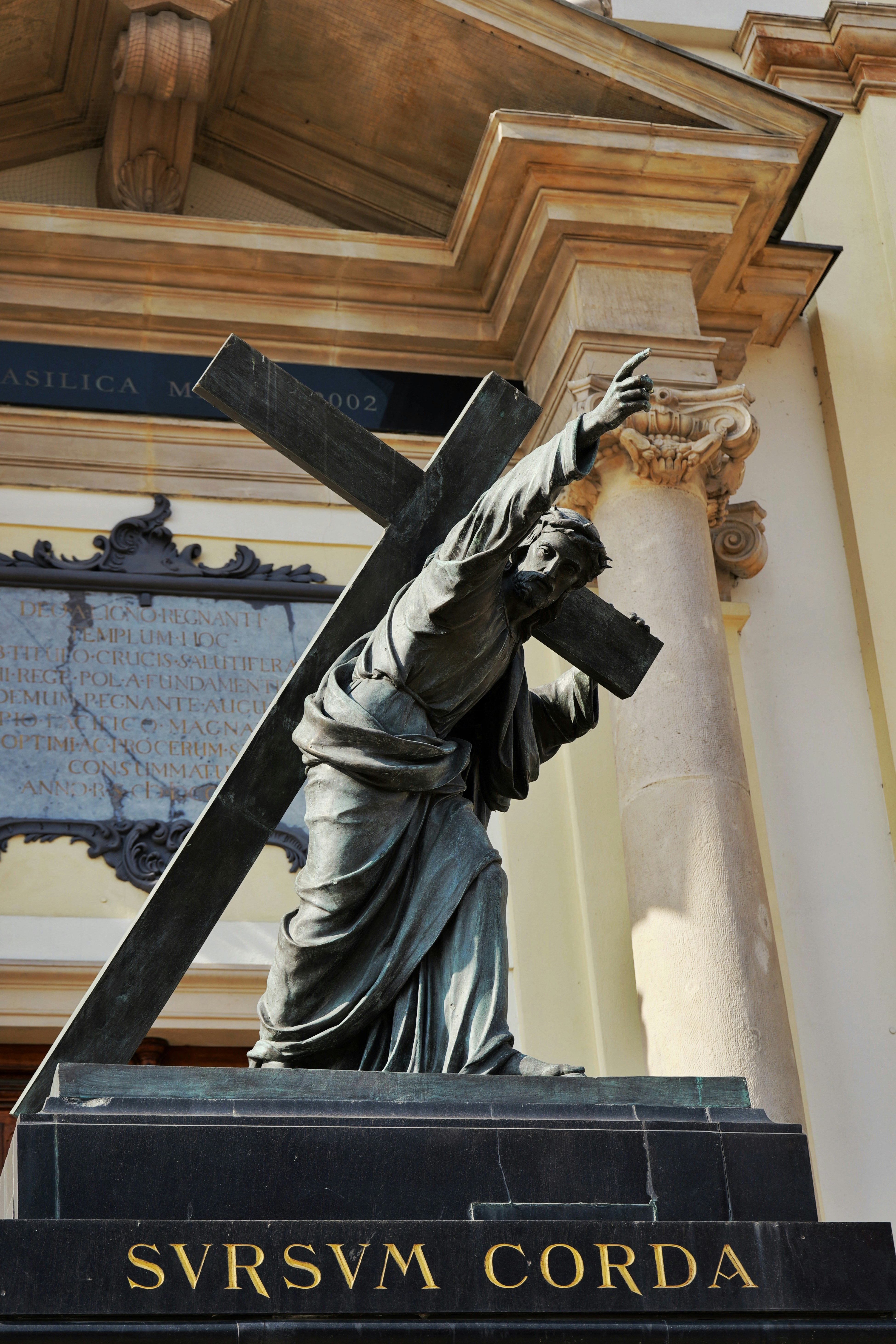 Cross-bearing Saint: A solemn statue under classical architecture