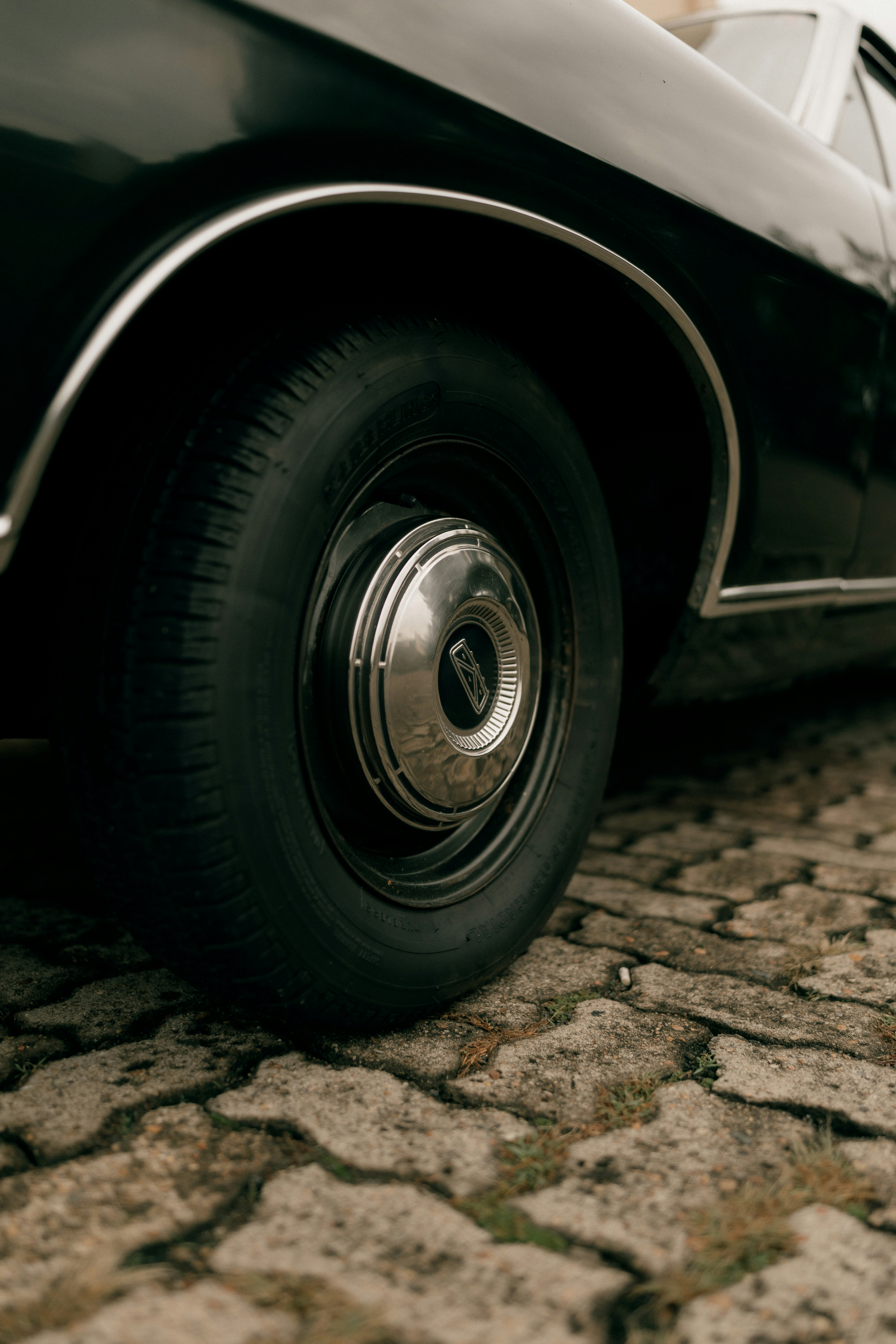 Wheel Close-Up: Vintage Car Hub and Cobblestone Edge