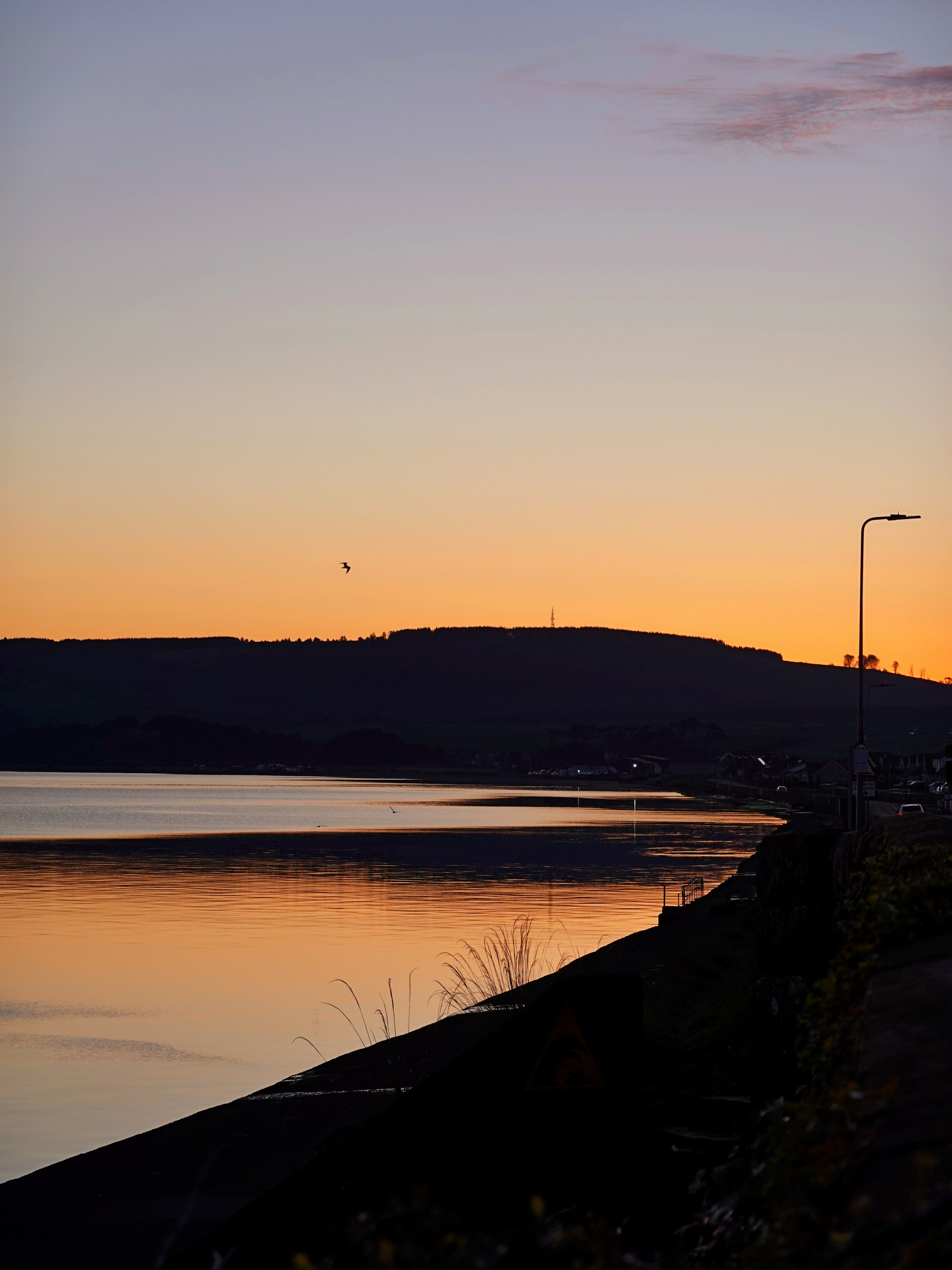 Sunset Over Quiet Estuary: A Distant Horizon and Gentle Ripples