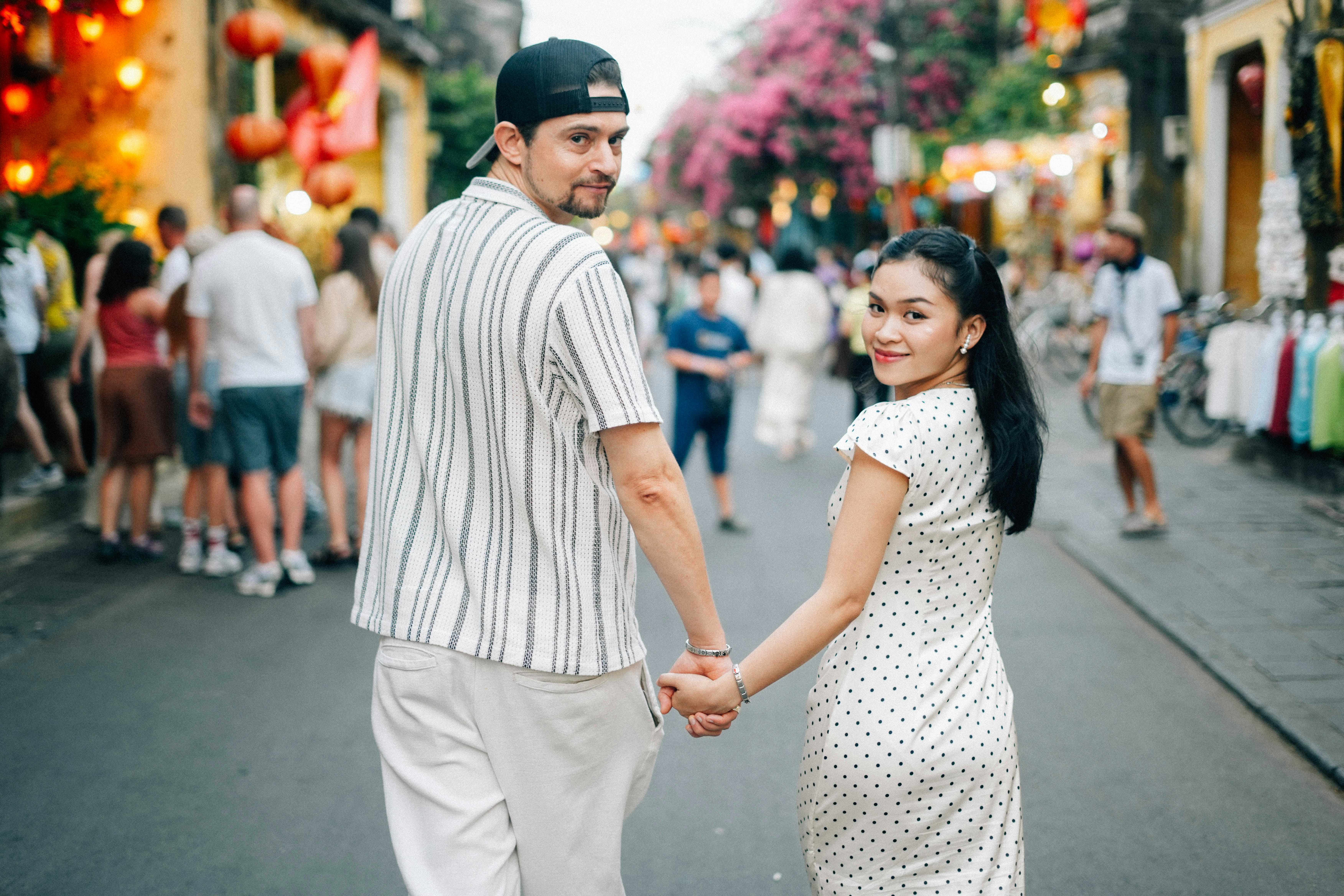 Street Serenade: A Couple Glances Back as They Walk Hand in Hand