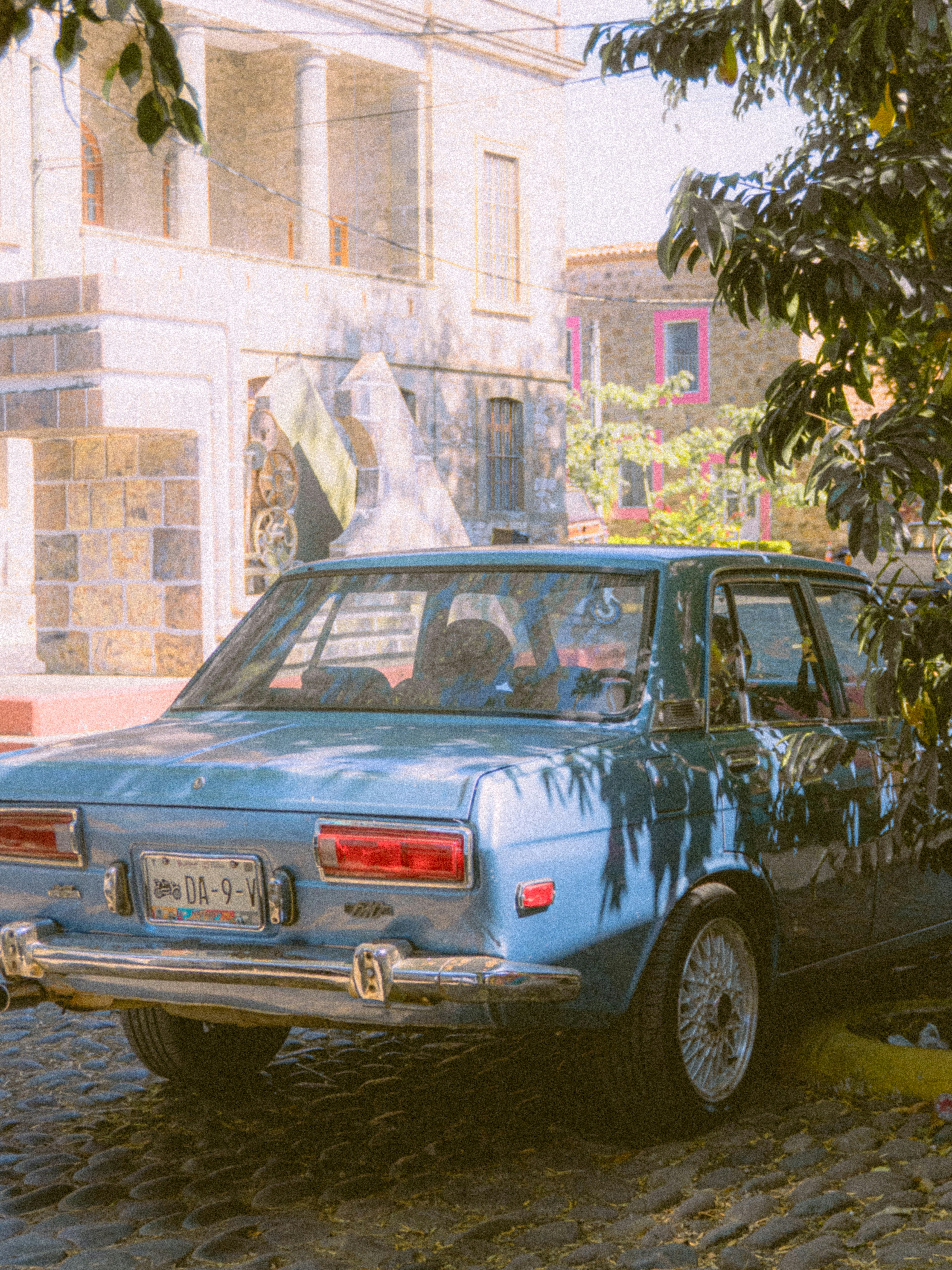 Blue Vintage Sedan under Cobblestone Evening Glow