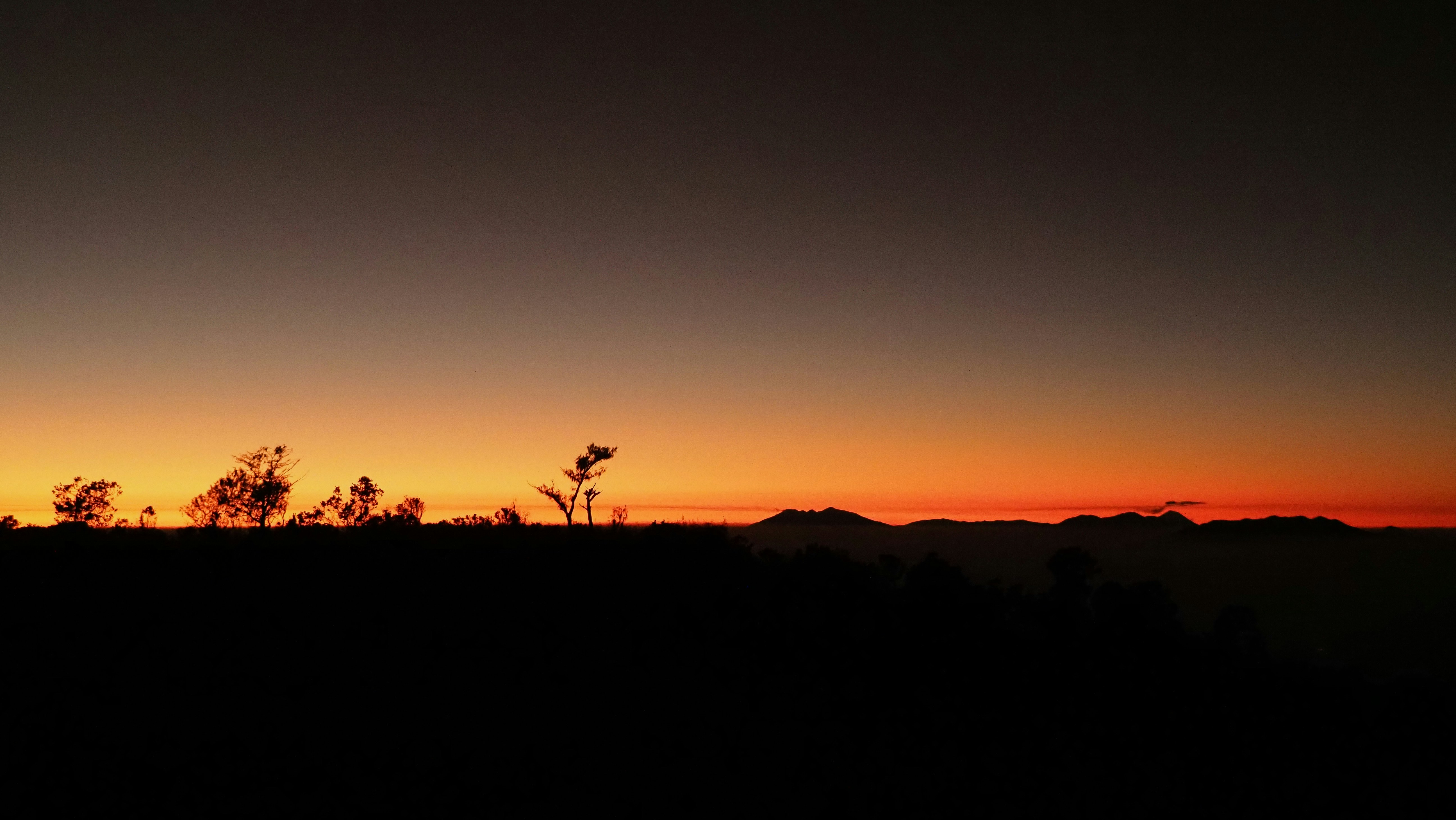 Distant horizon at sunset: silhouettes against a fading gradient
