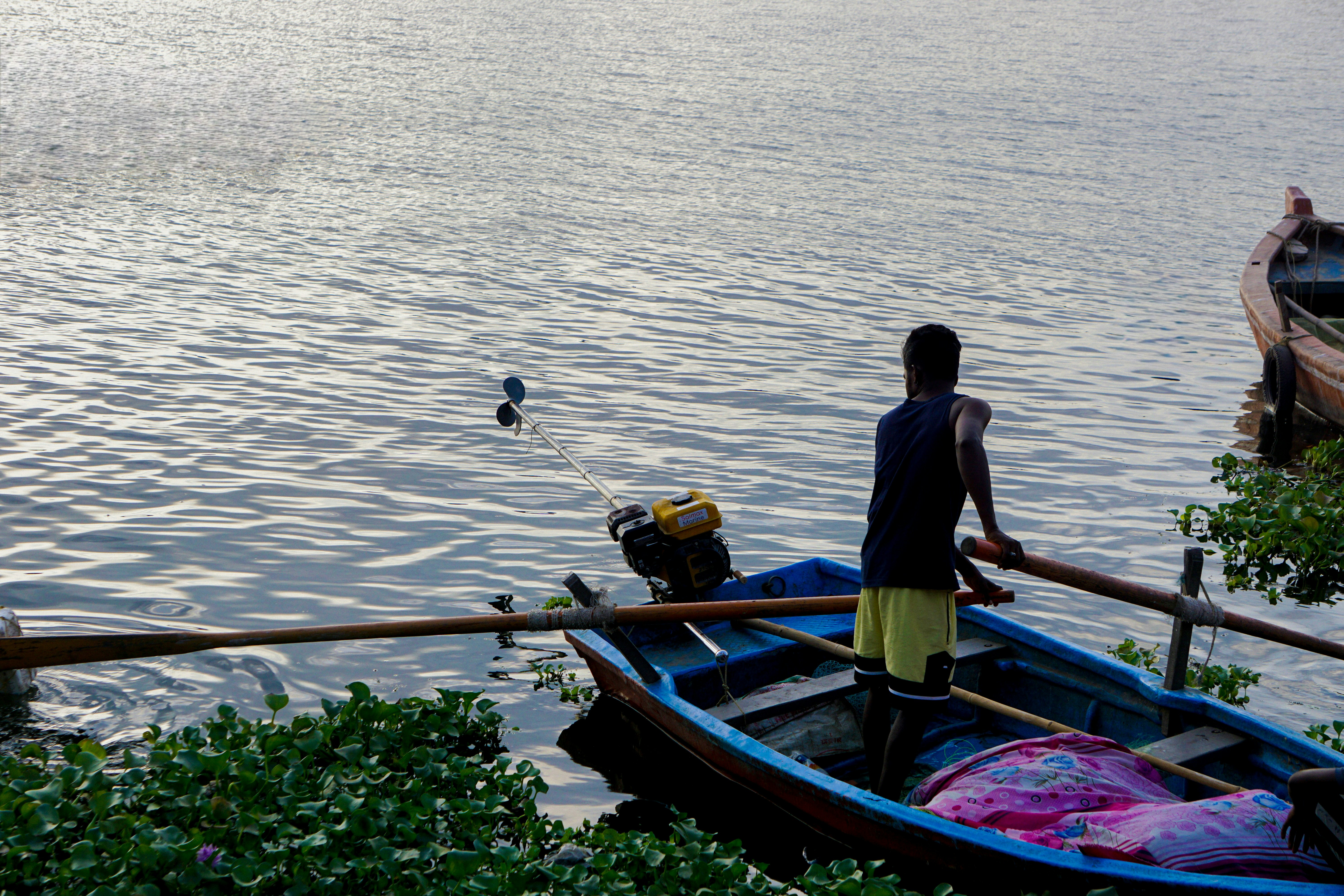 Boatman at the Water's Edge: A Quiet Moment by the Shore