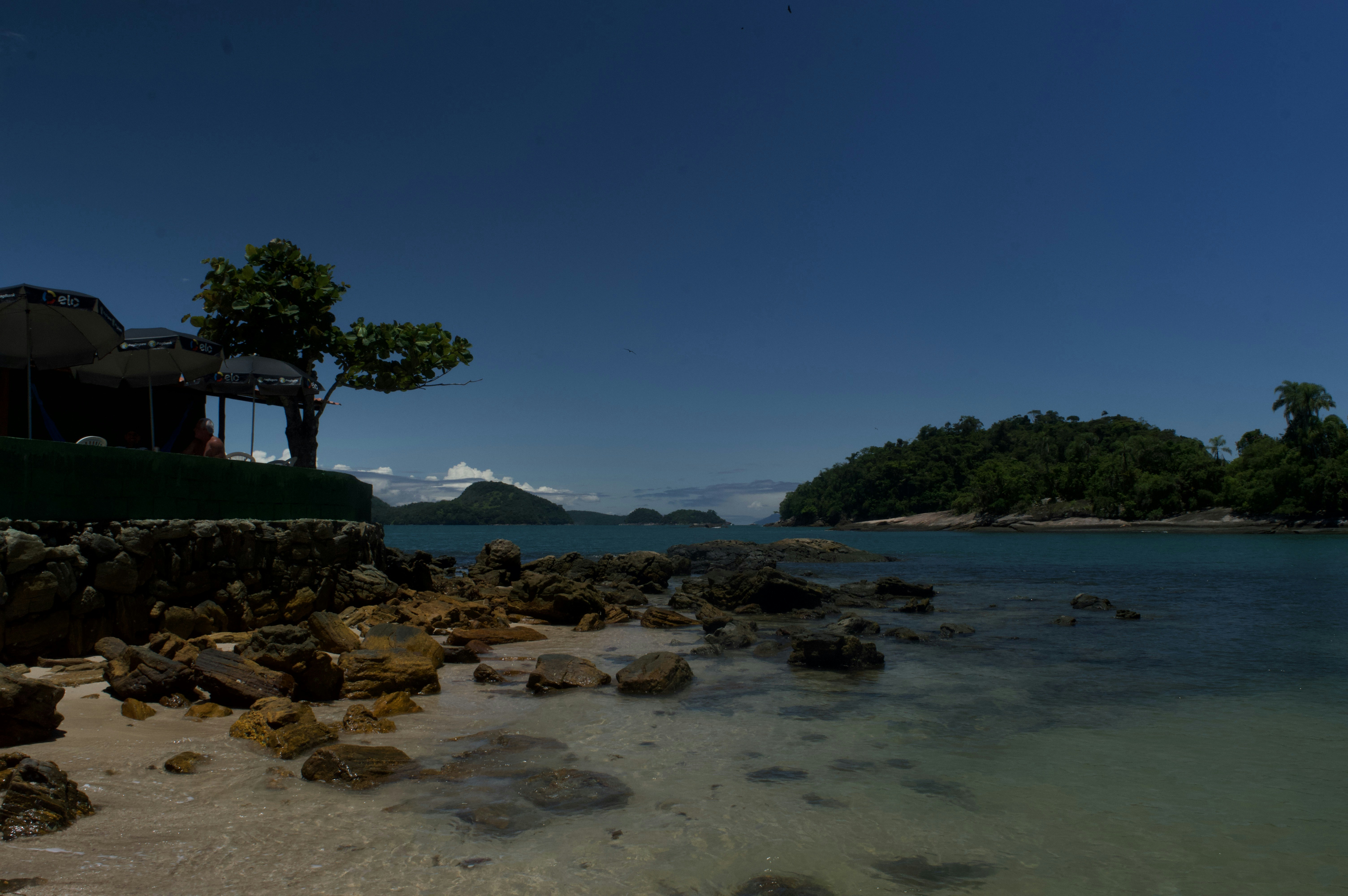 Limestone shoreline and turquoise water under a tranquil noon sky