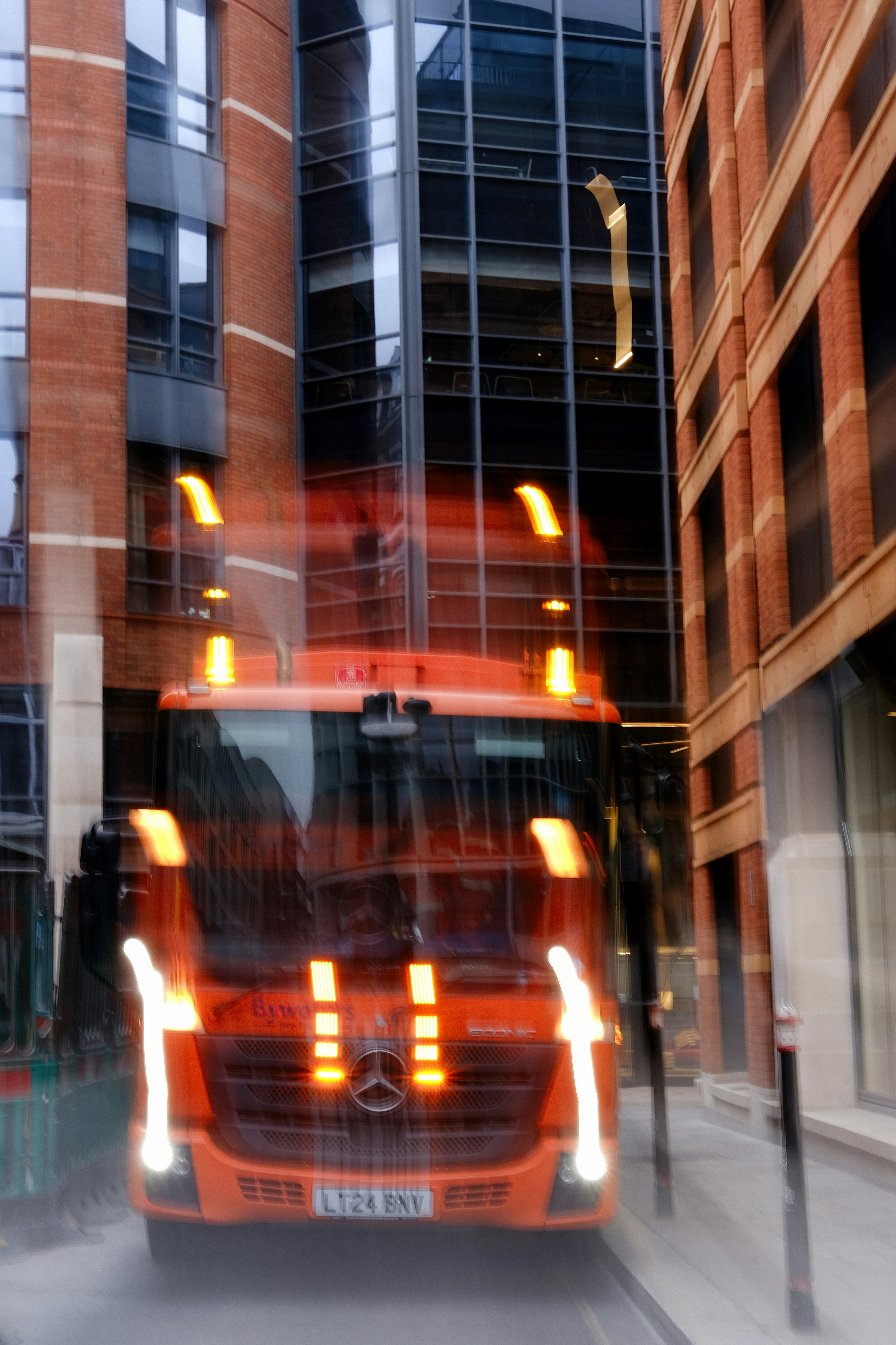 Rushing City Rescue: Orange Fire Truck Breaks Through a Blurred Street
