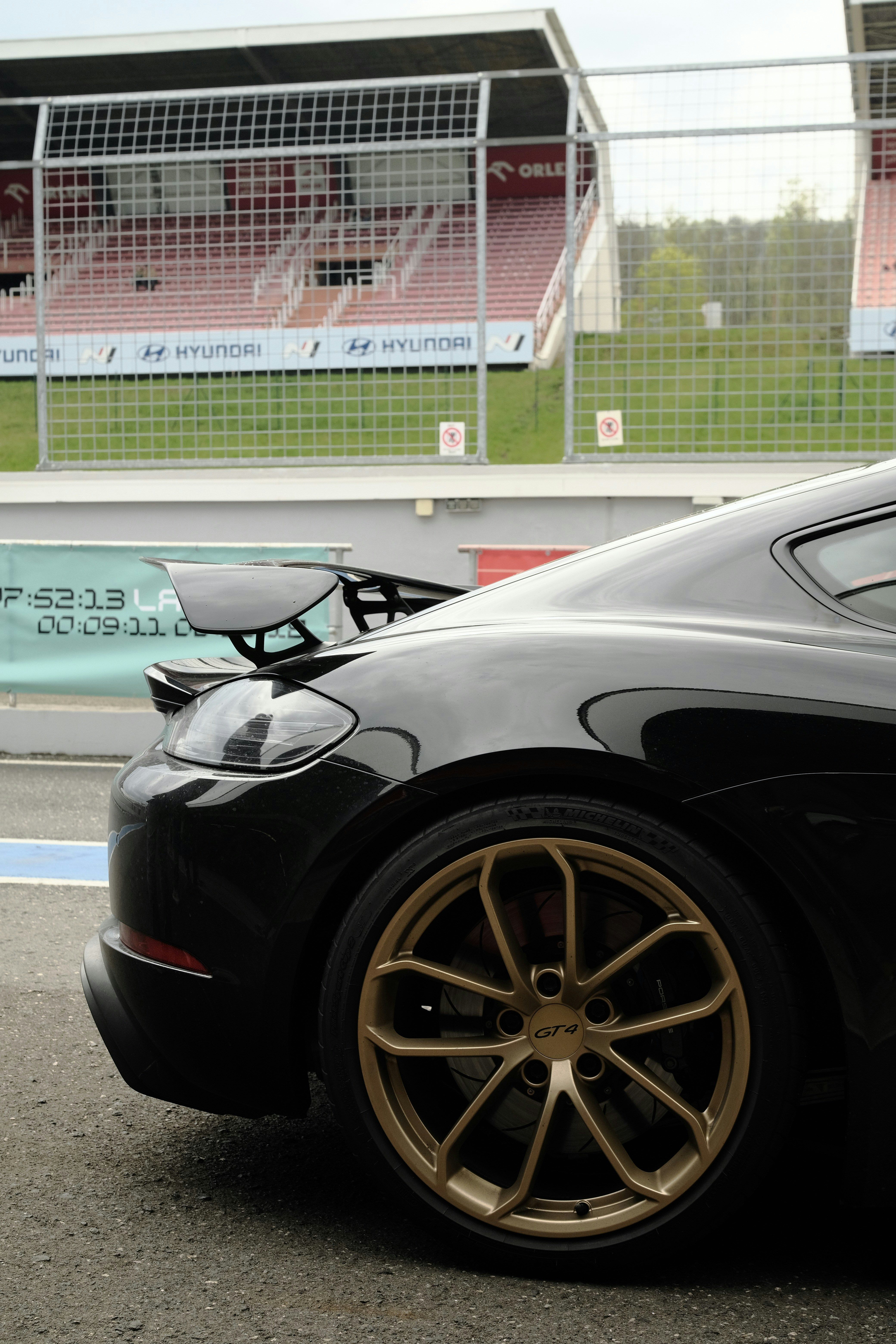 Rear Wing and Golden Alloy: A Track-Ready Porsche at the Paddock