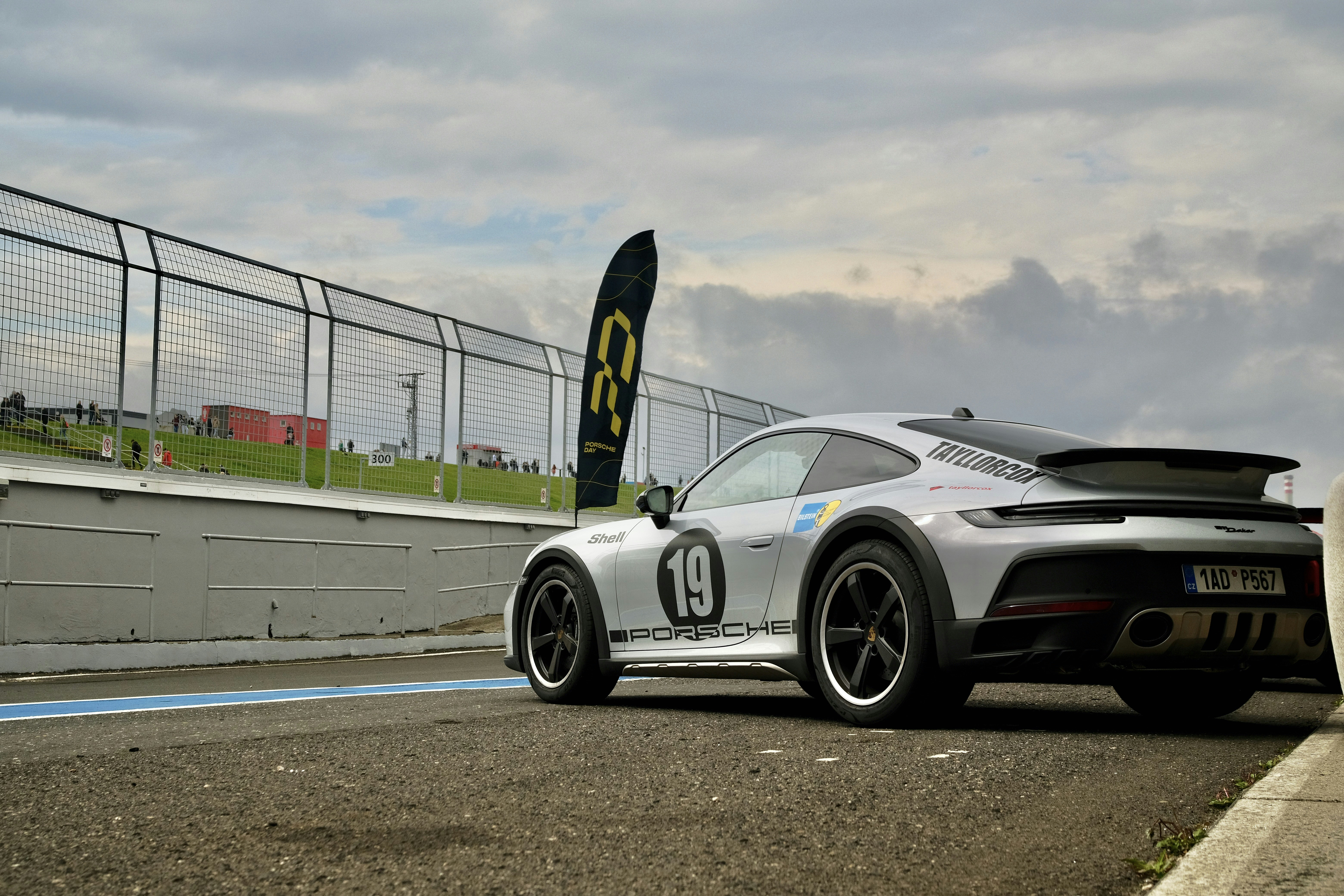 Porsche GT on Circuit Gravel: A Silver Streak at the Edge of Track