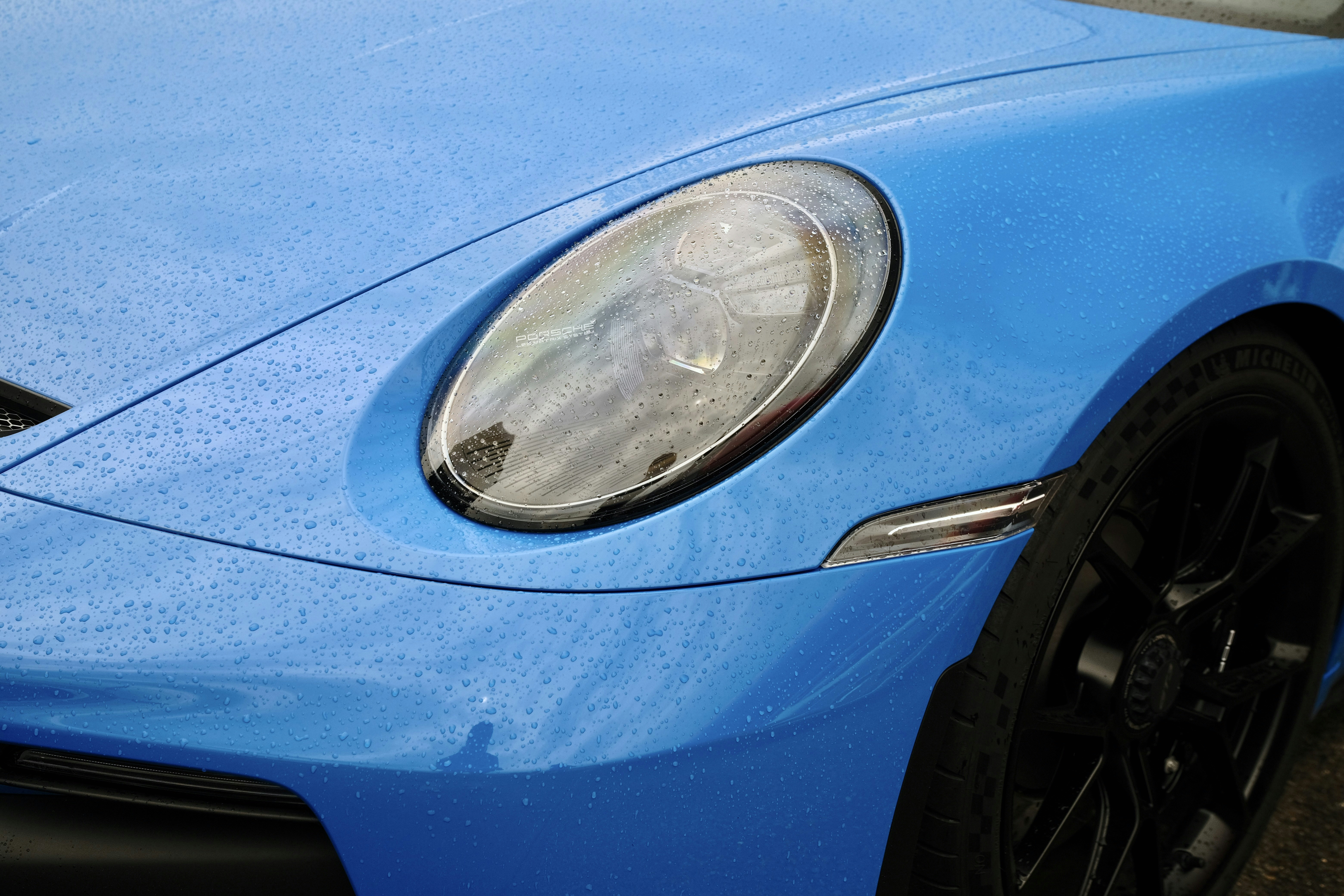 Blue Porsche Front Quarter: Water Droplets, Curved Headlight
