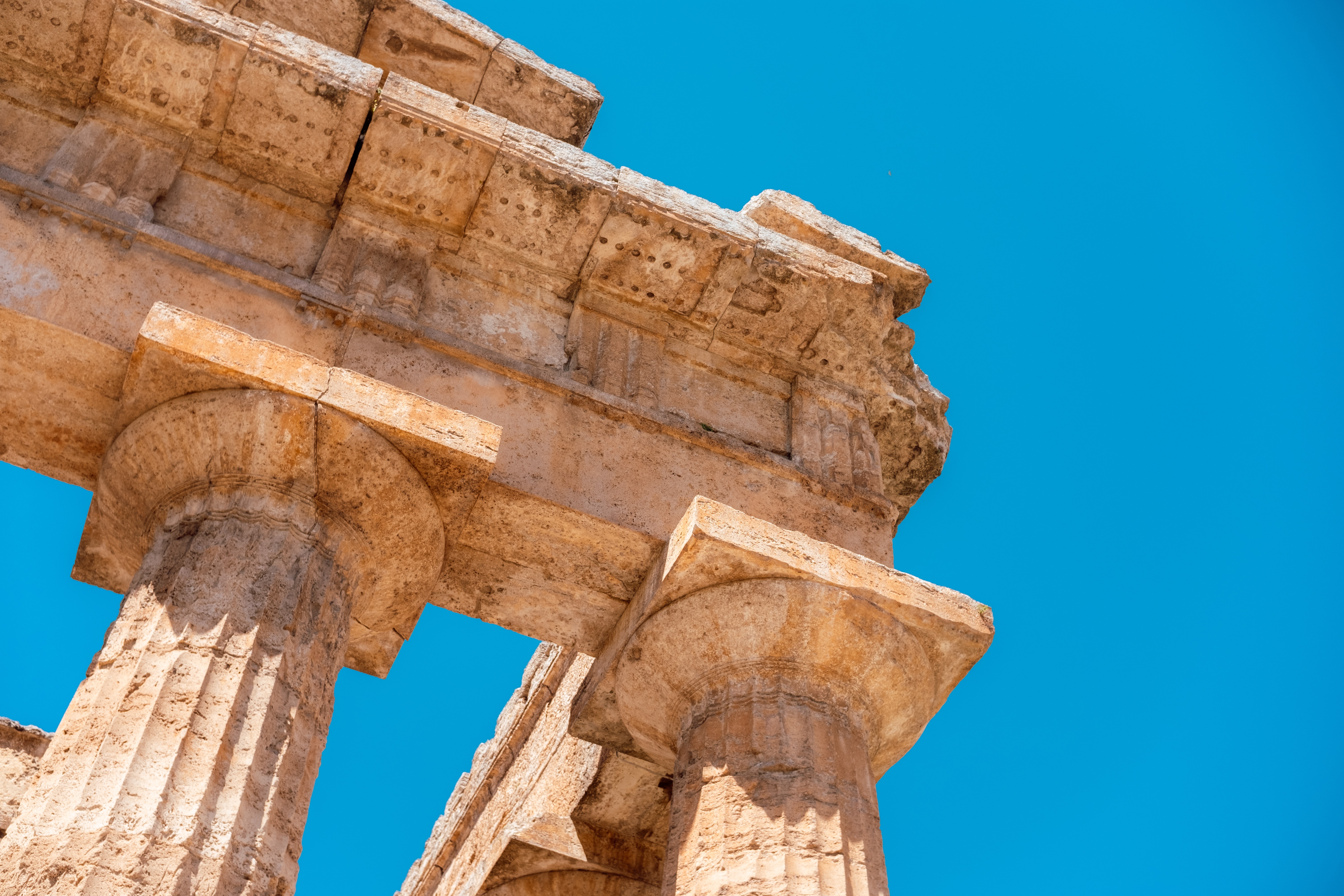 Sunlit Ruins: Carved Columns Reaching Toward a Cerulean Sky
