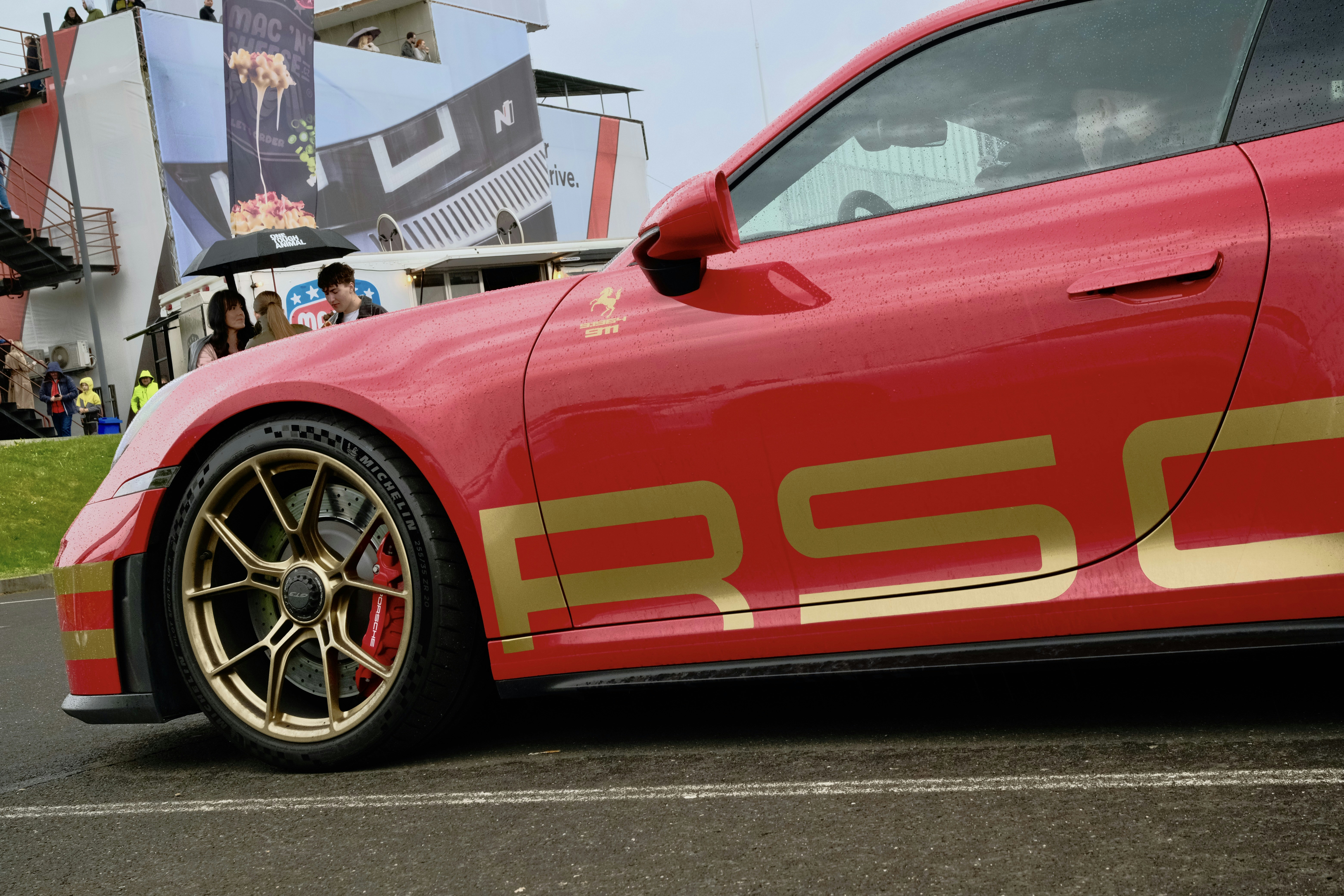 Red Porsche Gathers Speed: A Close-Up of Aerodynamic Contours and Golden Decals