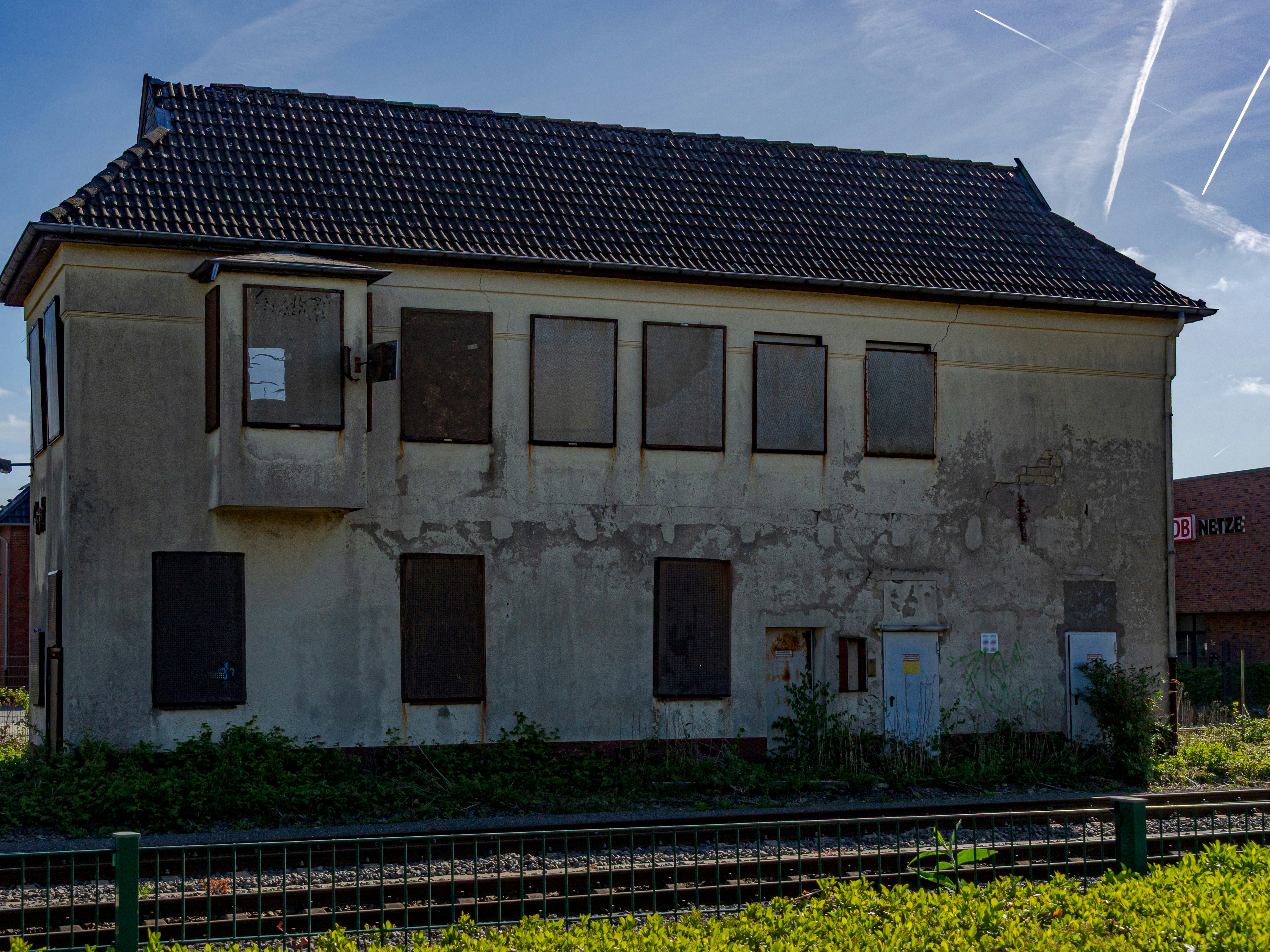 Abandoned Railway House: Weathered Facade Above Tracks