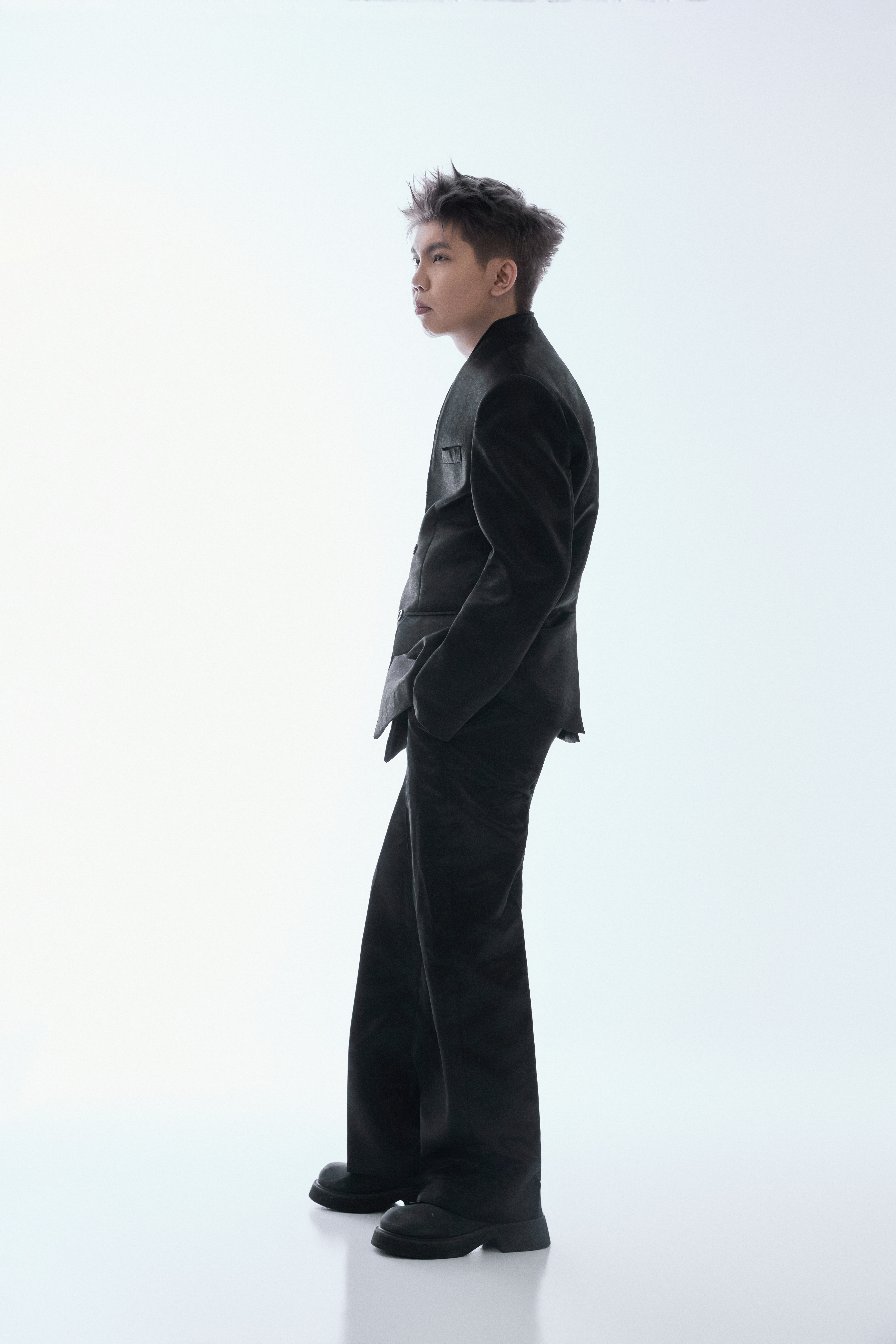 Portrait in Shadow: A Suited Figure Steps into Soft Studio Light